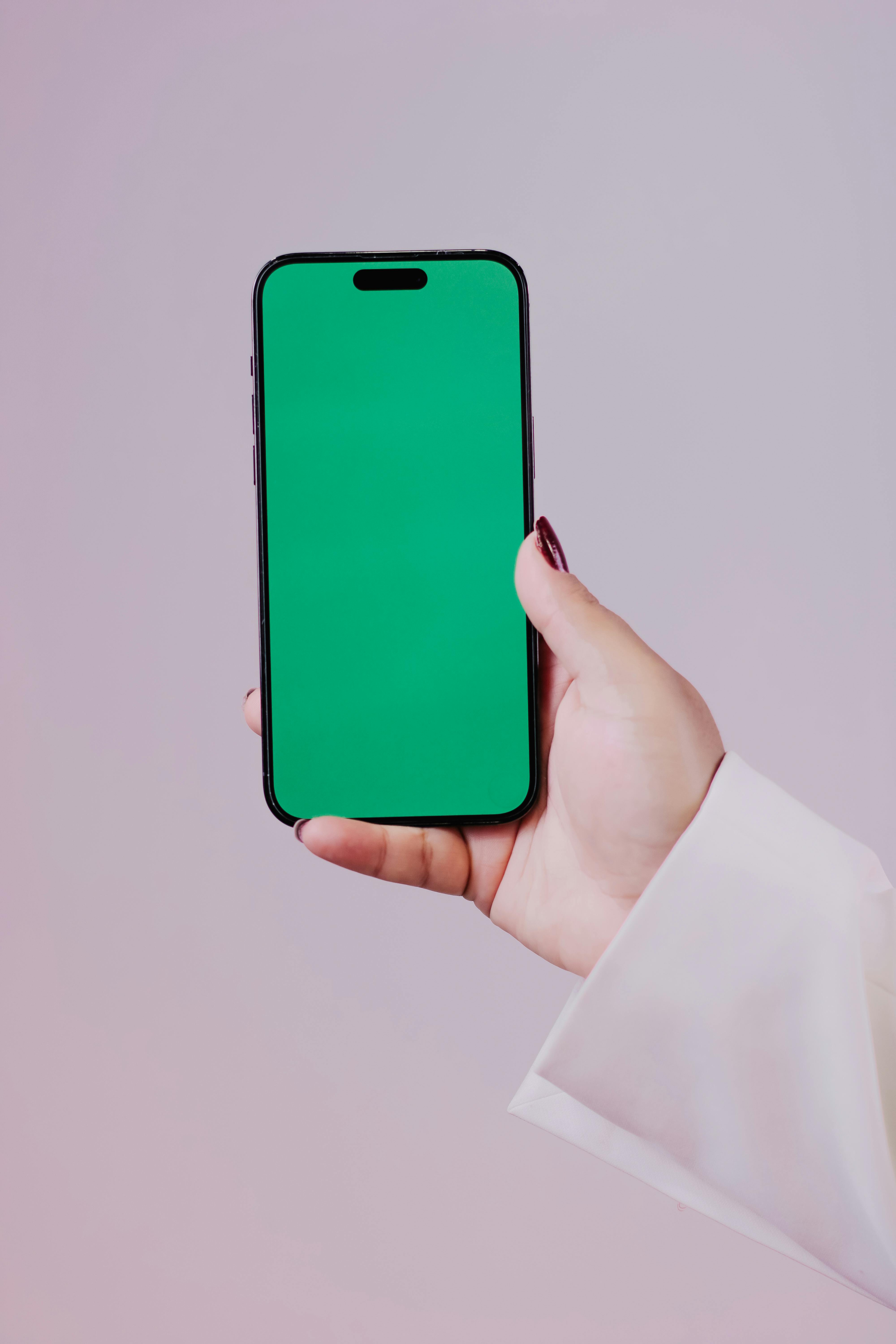 Telefone Com Tela Verde Na Mão · Foto profissional gratuita