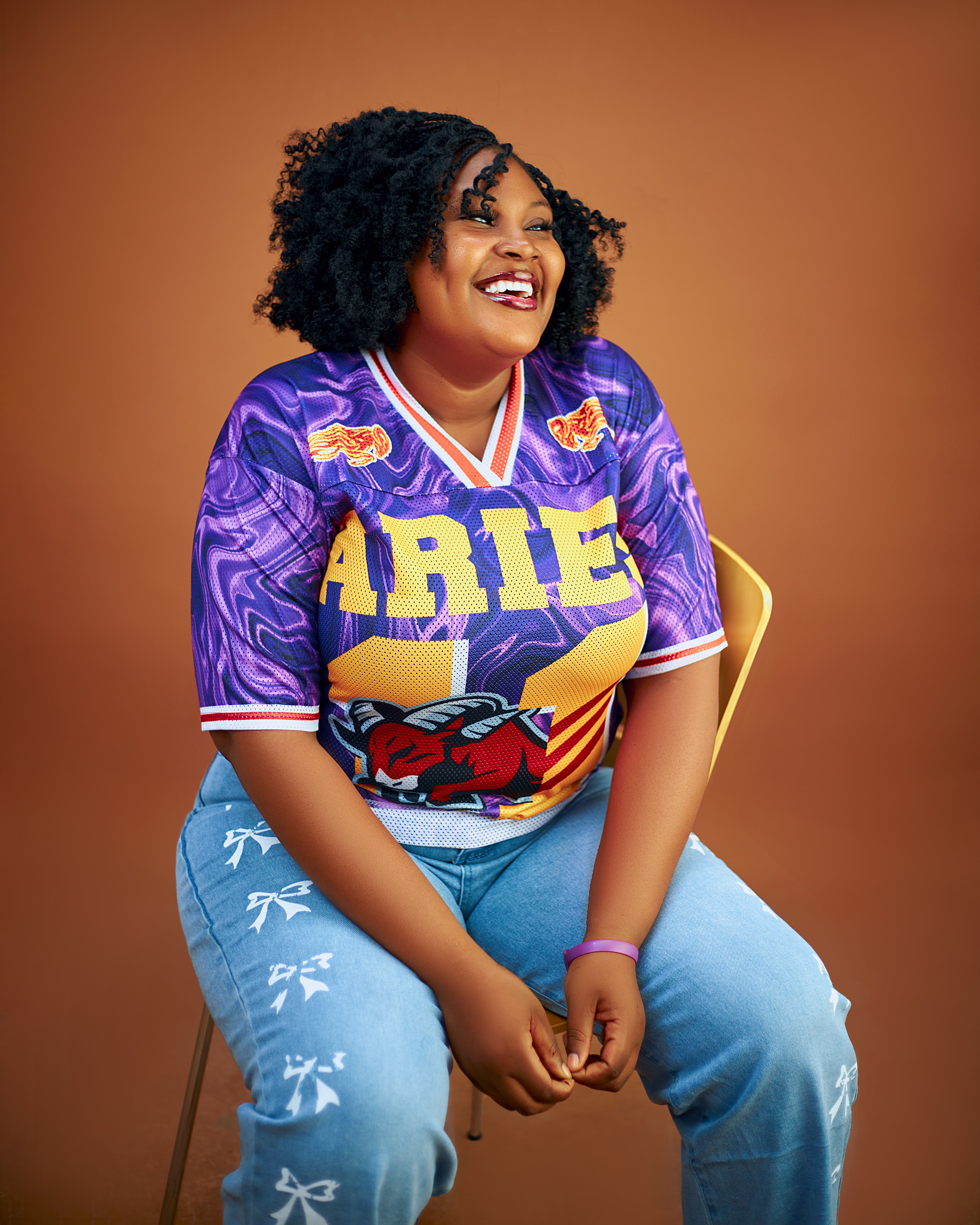 Smiling Woman in Colorful Aries Sports Jersey · Free Stock Photo
