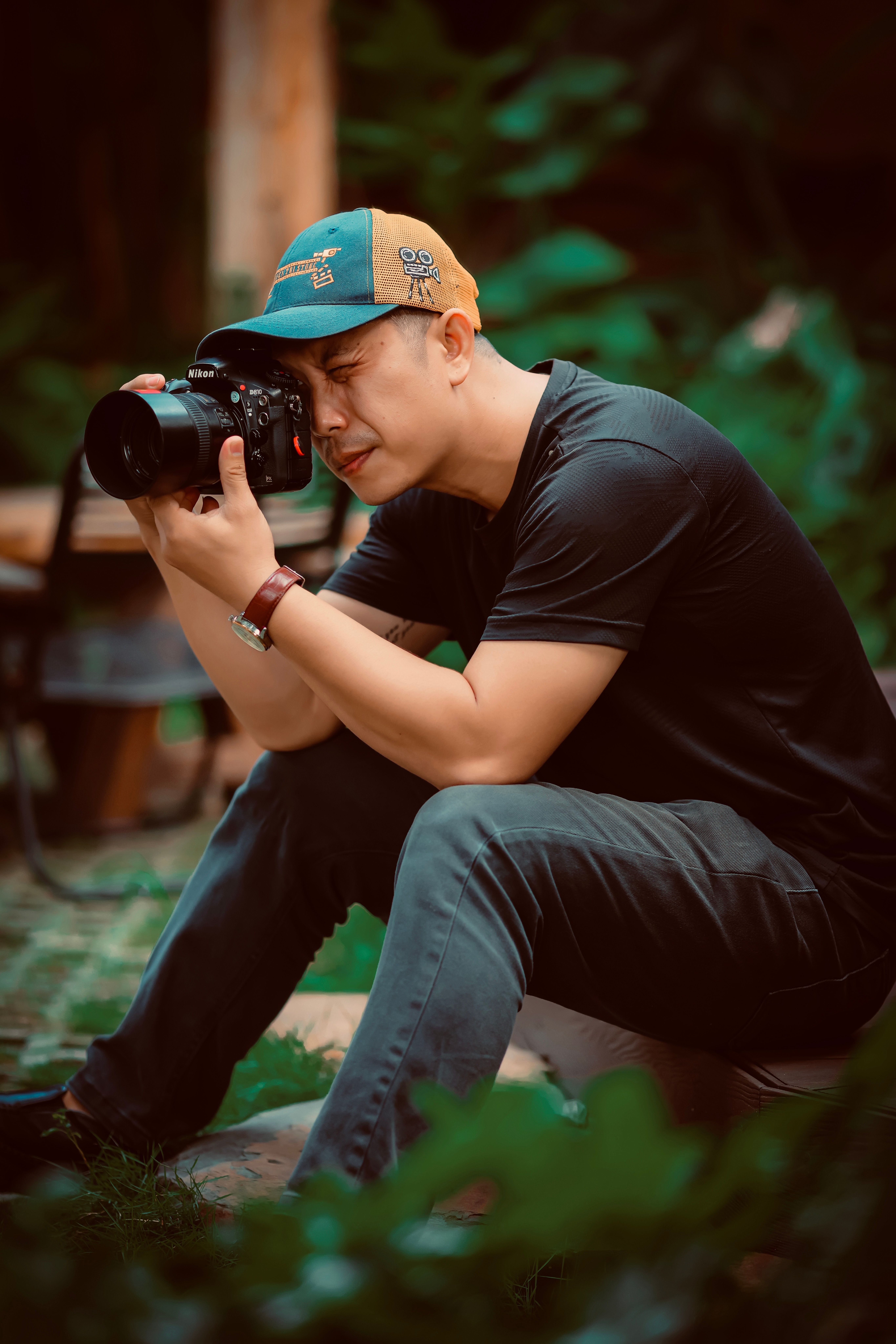 Young Man Capturing Nature with Camera Outdoors · Free Stock Photo