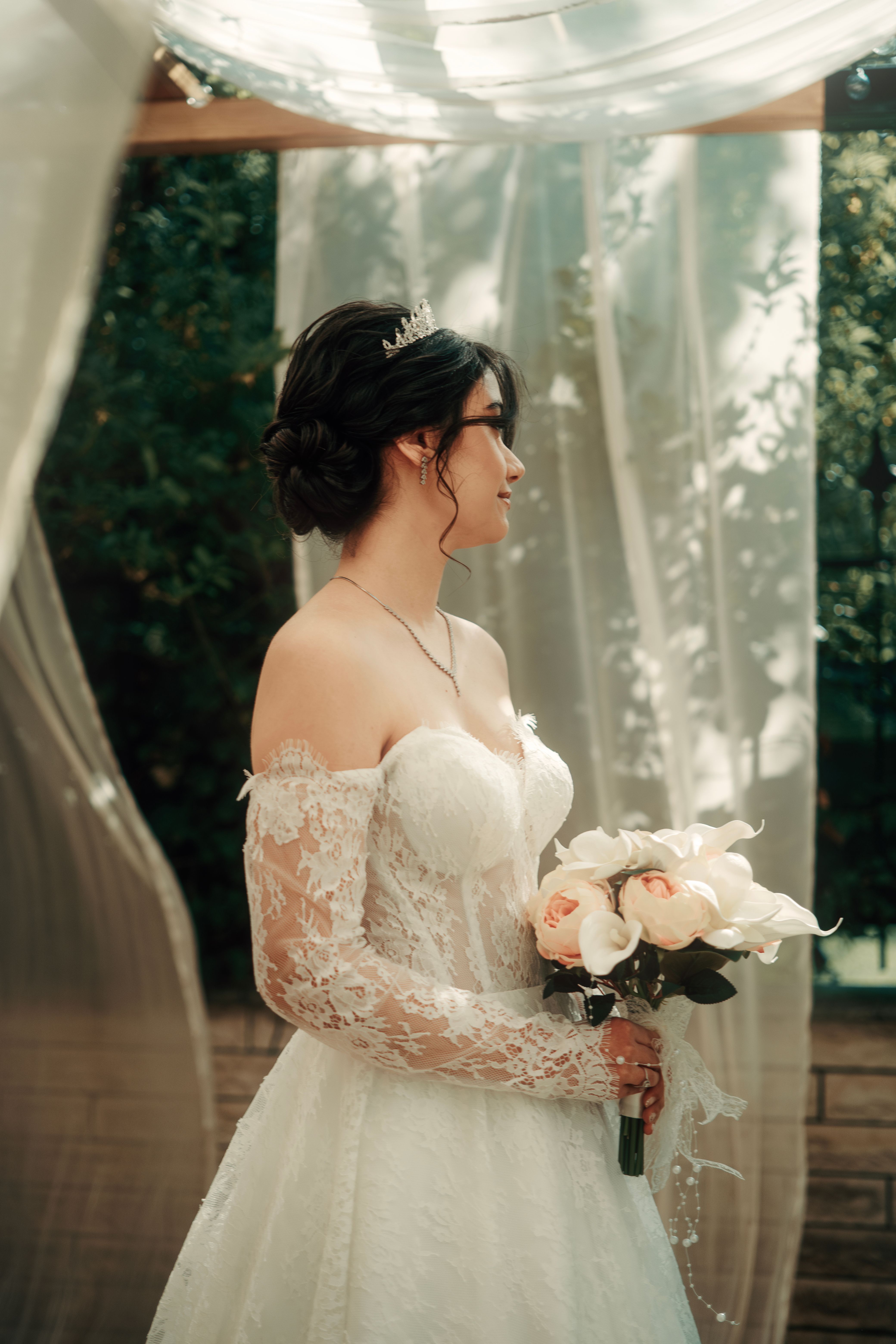 Elegant Bride in Lace Gown Holding Bouquet · Free Stock Photo