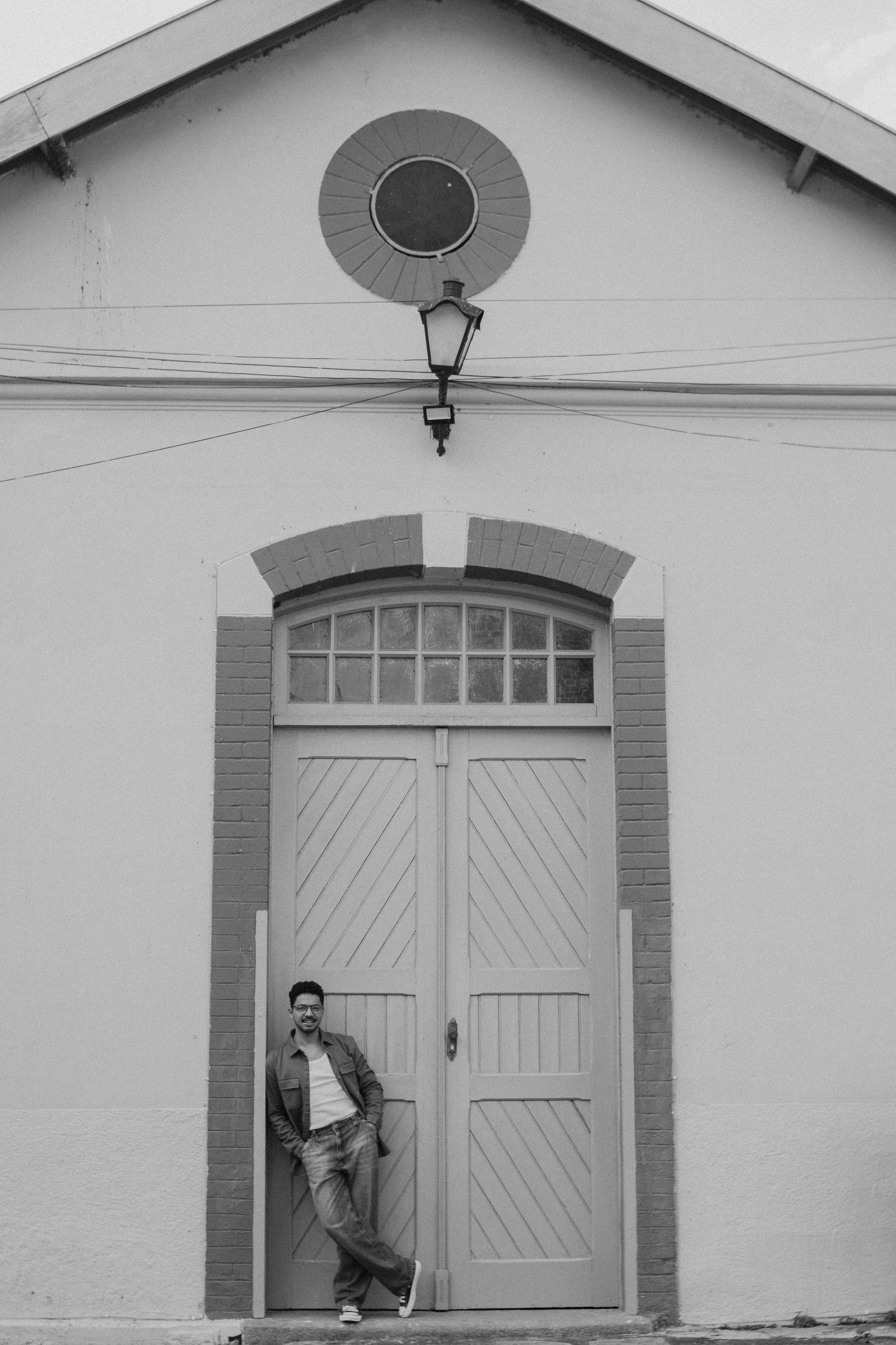 Man Leaning on Large Door of Historic Building · Free Stock Photo