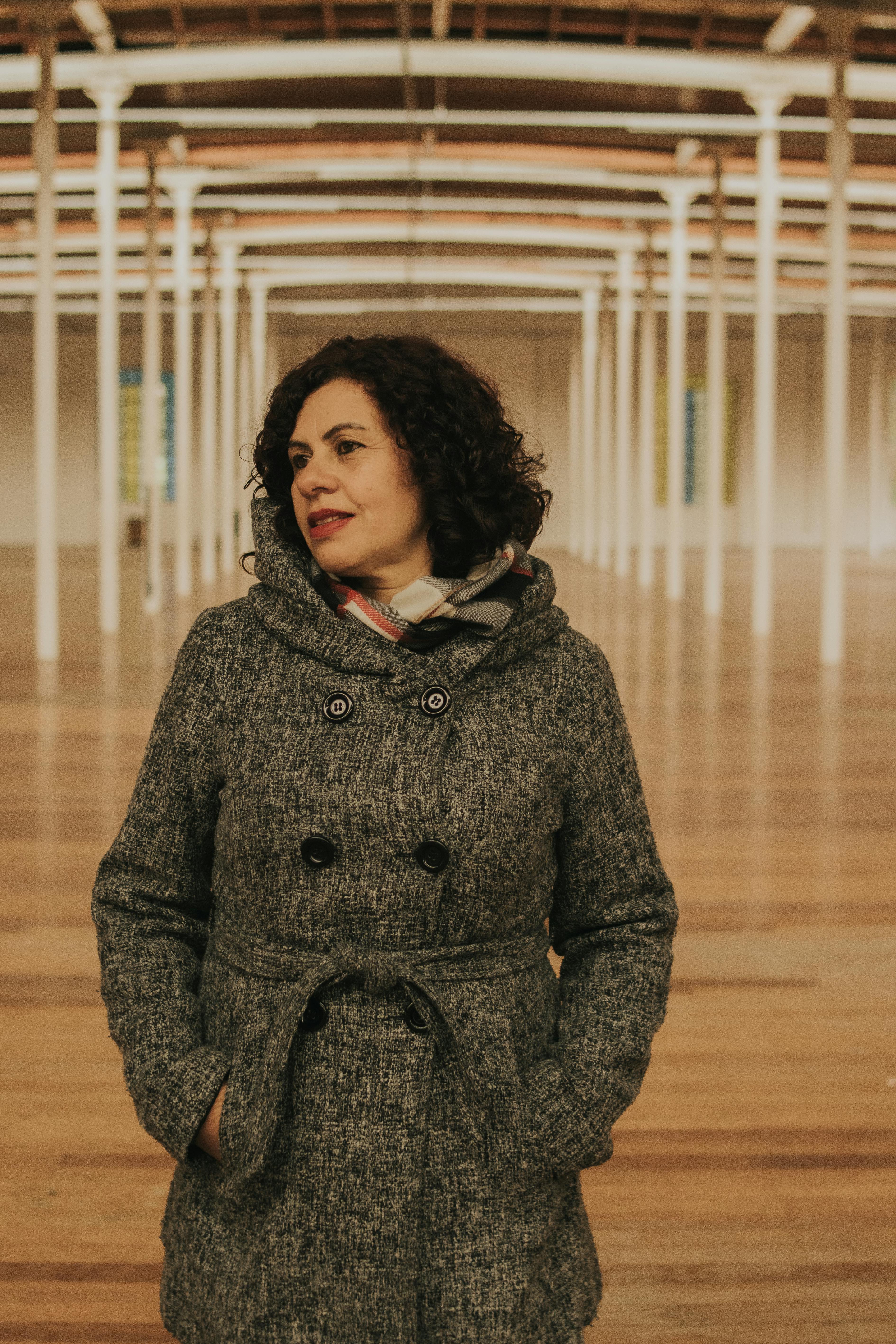 Woman in Gray Coat Inside Industrial Building · Free Stock Photo