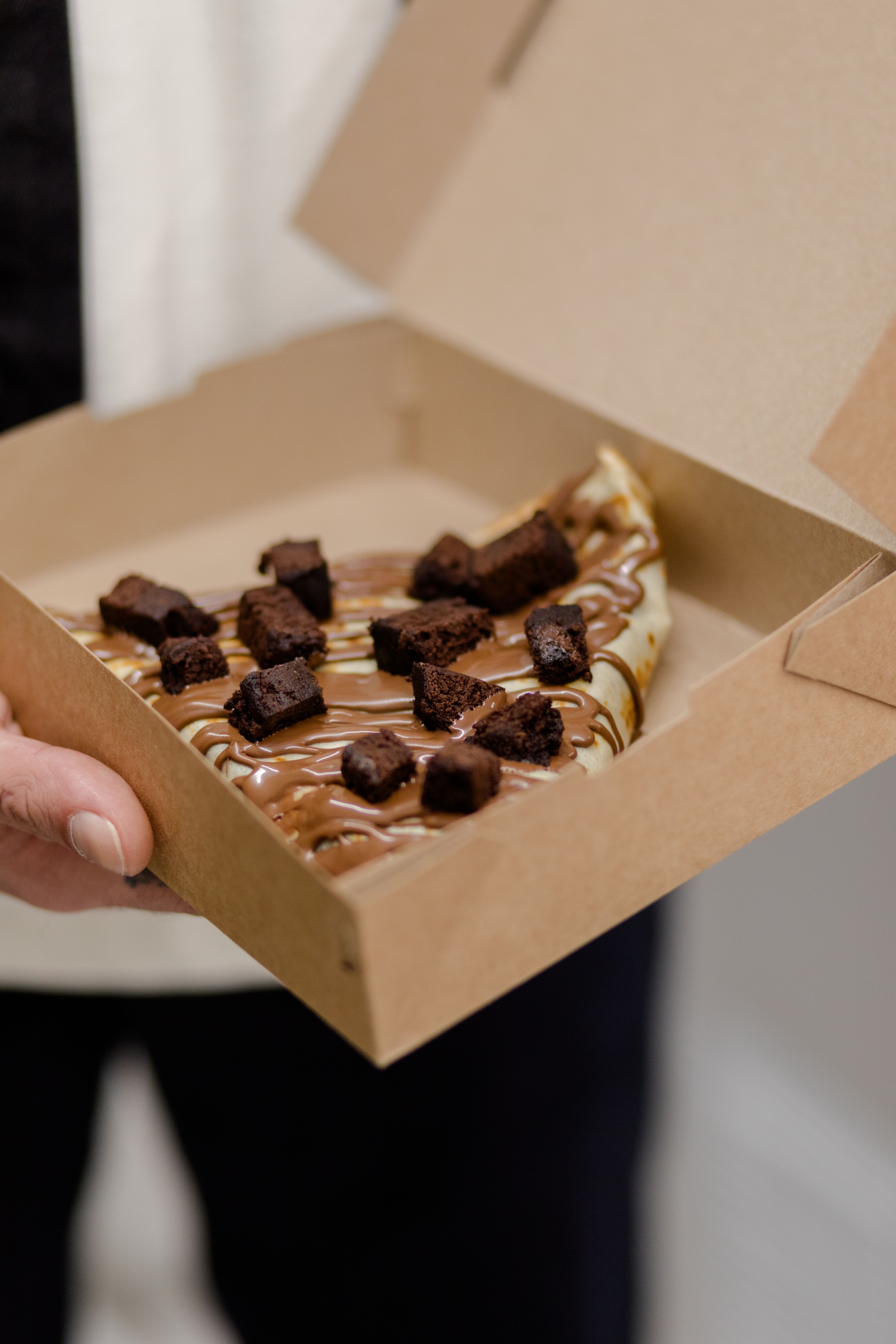 Closeup of a Hand Holding a Chocolate Snack in a Paper Box · Free Stock ...