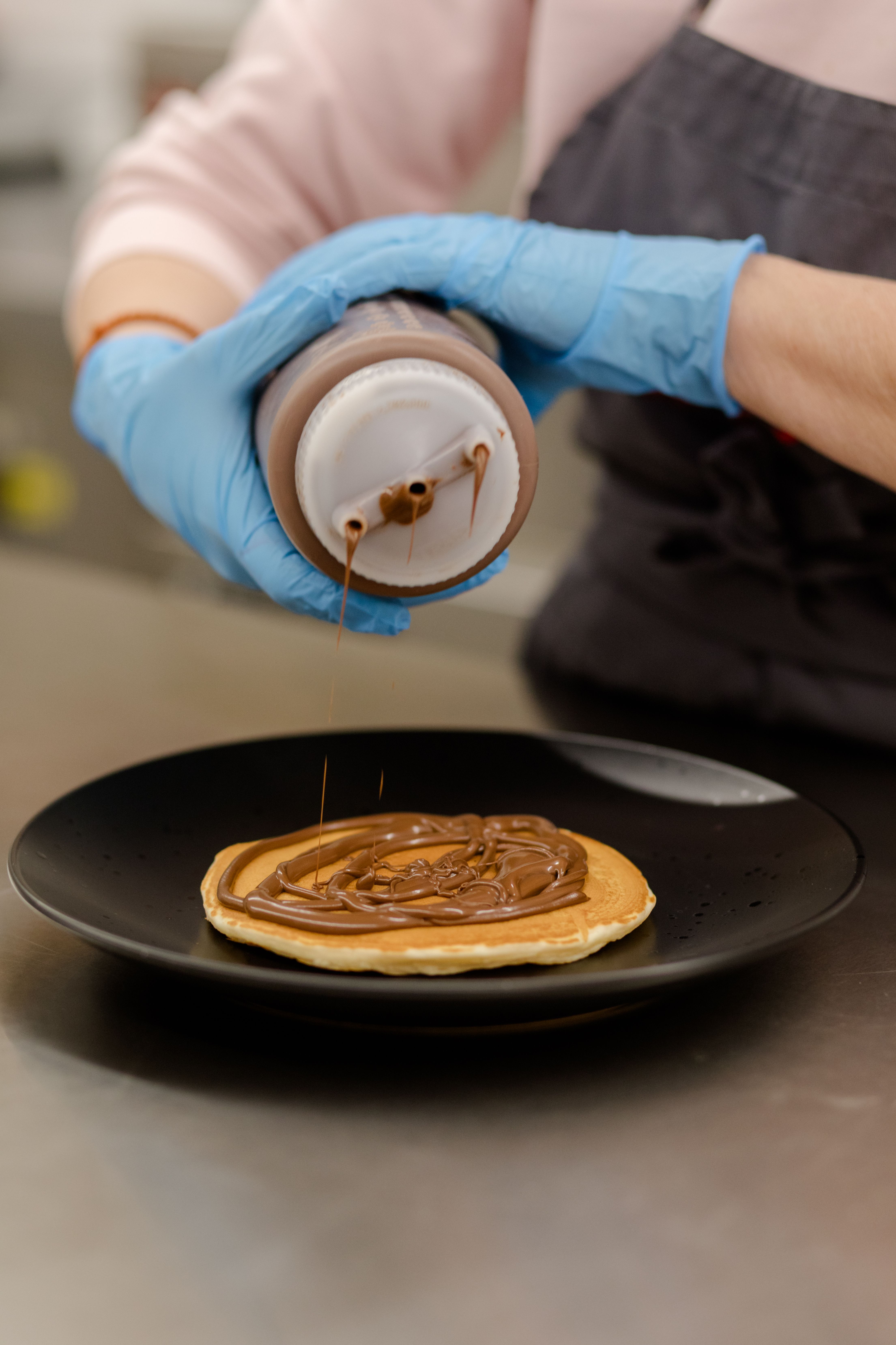 Person Decorating Pancake with Chocolate · Free Stock Photo