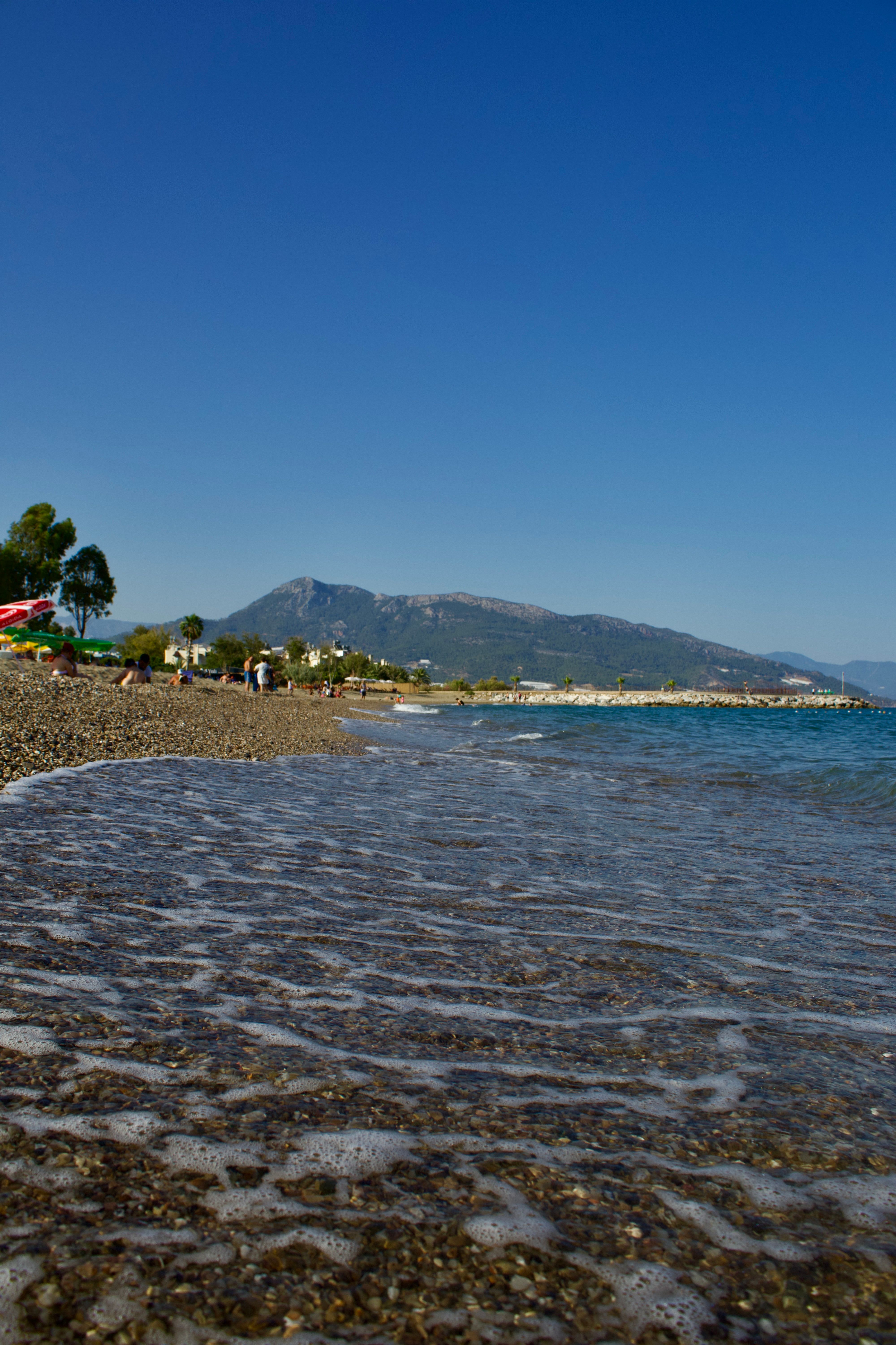 Sunny Mediterranean Beach with Mountain View · Free Stock Photo