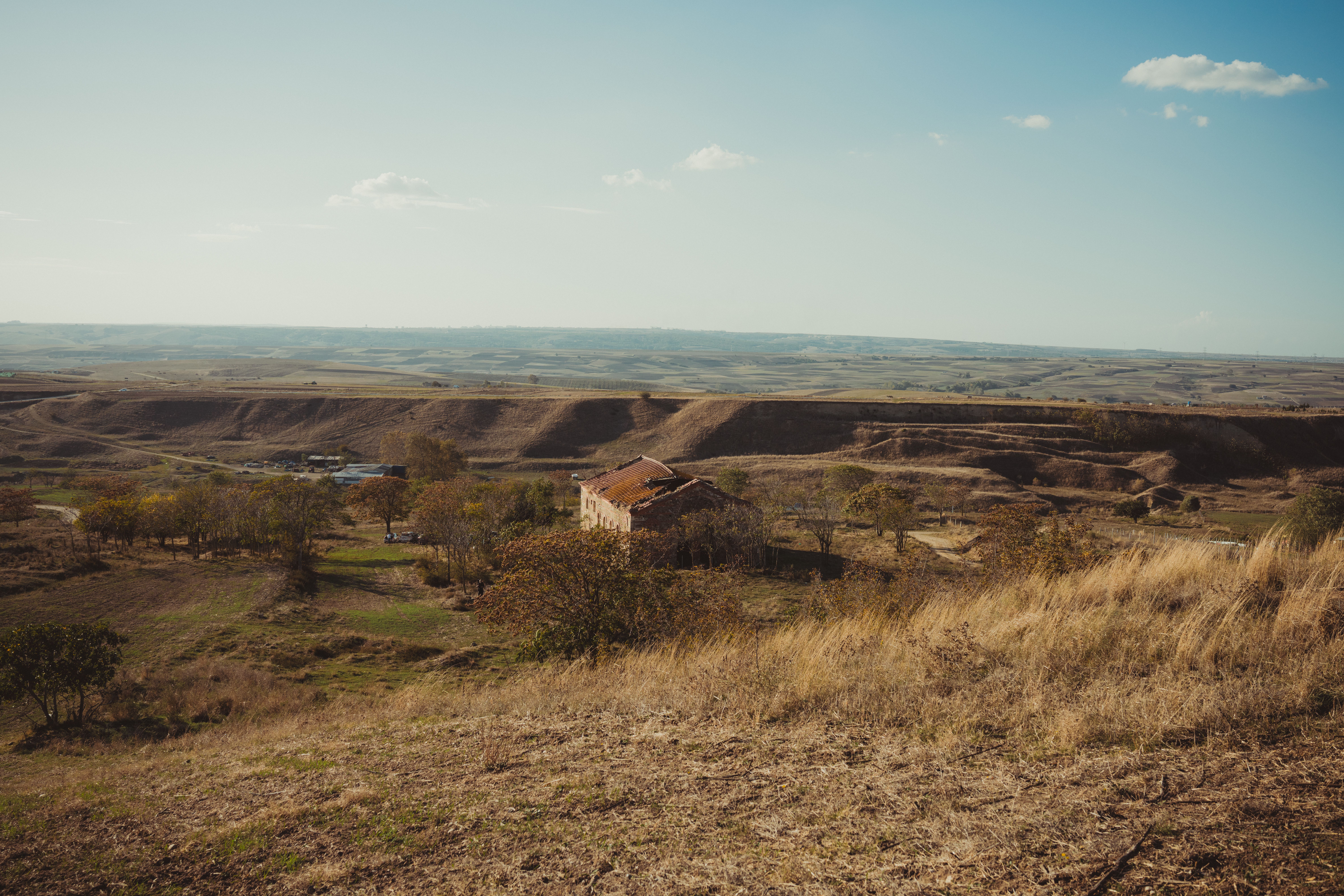 Rural Landscape with Rustic Building Under Blue Sky · Free Stock Photo
