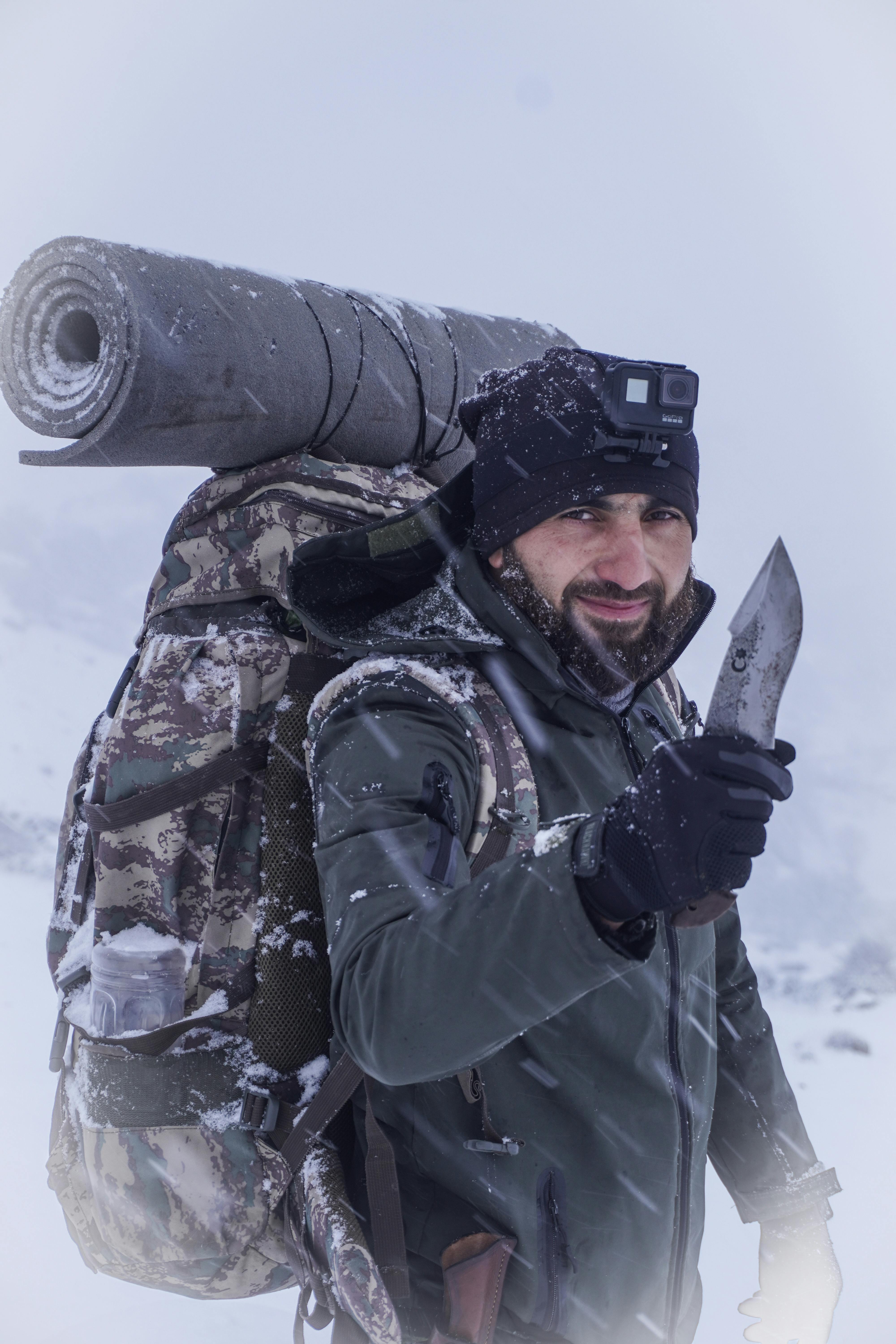 Adventurer with Knife in Snowy Wilderness · Free Stock Photo