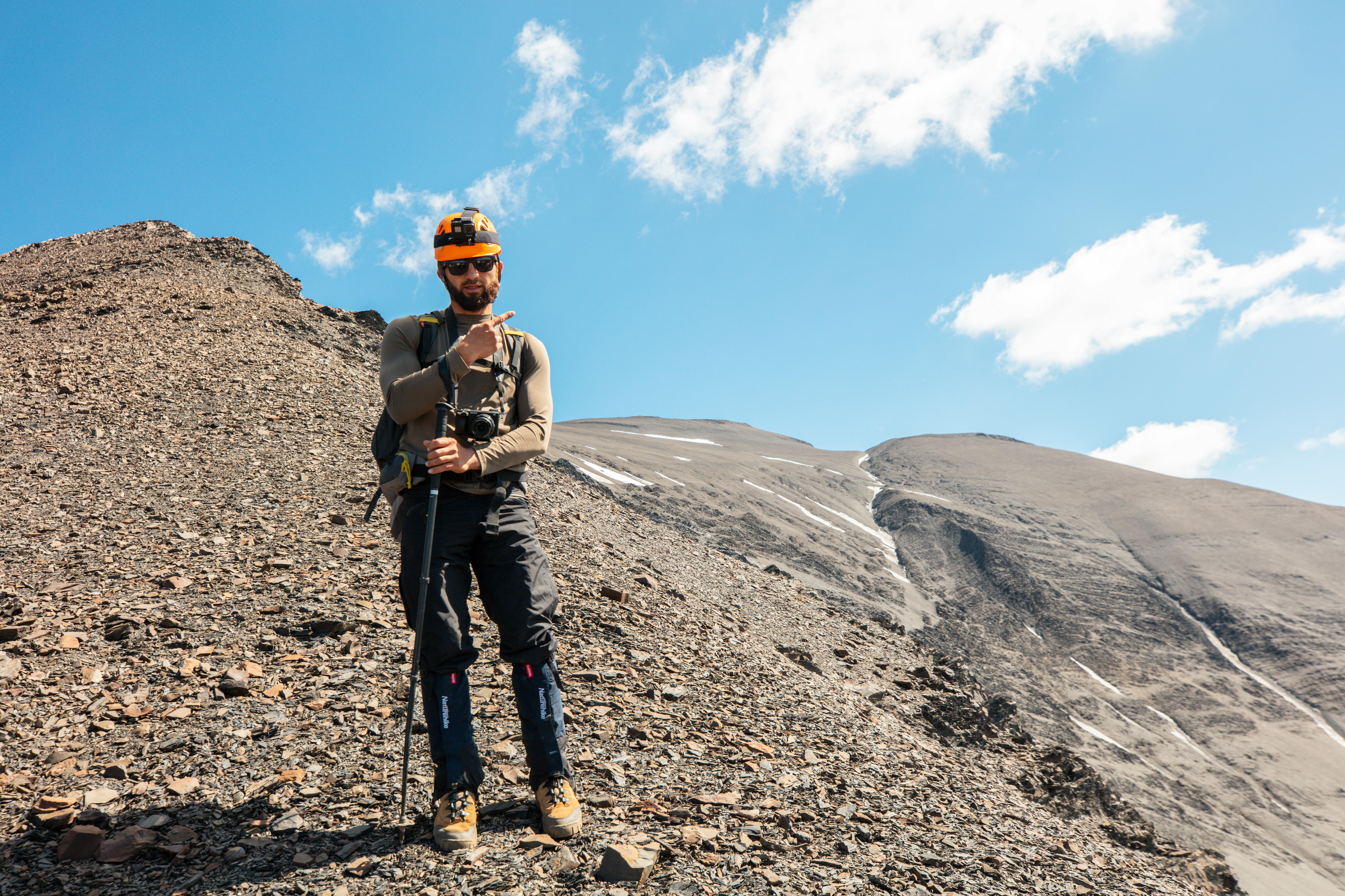 Mountain Hiker with Camera on Rocky Terrain · Free Stock Photo