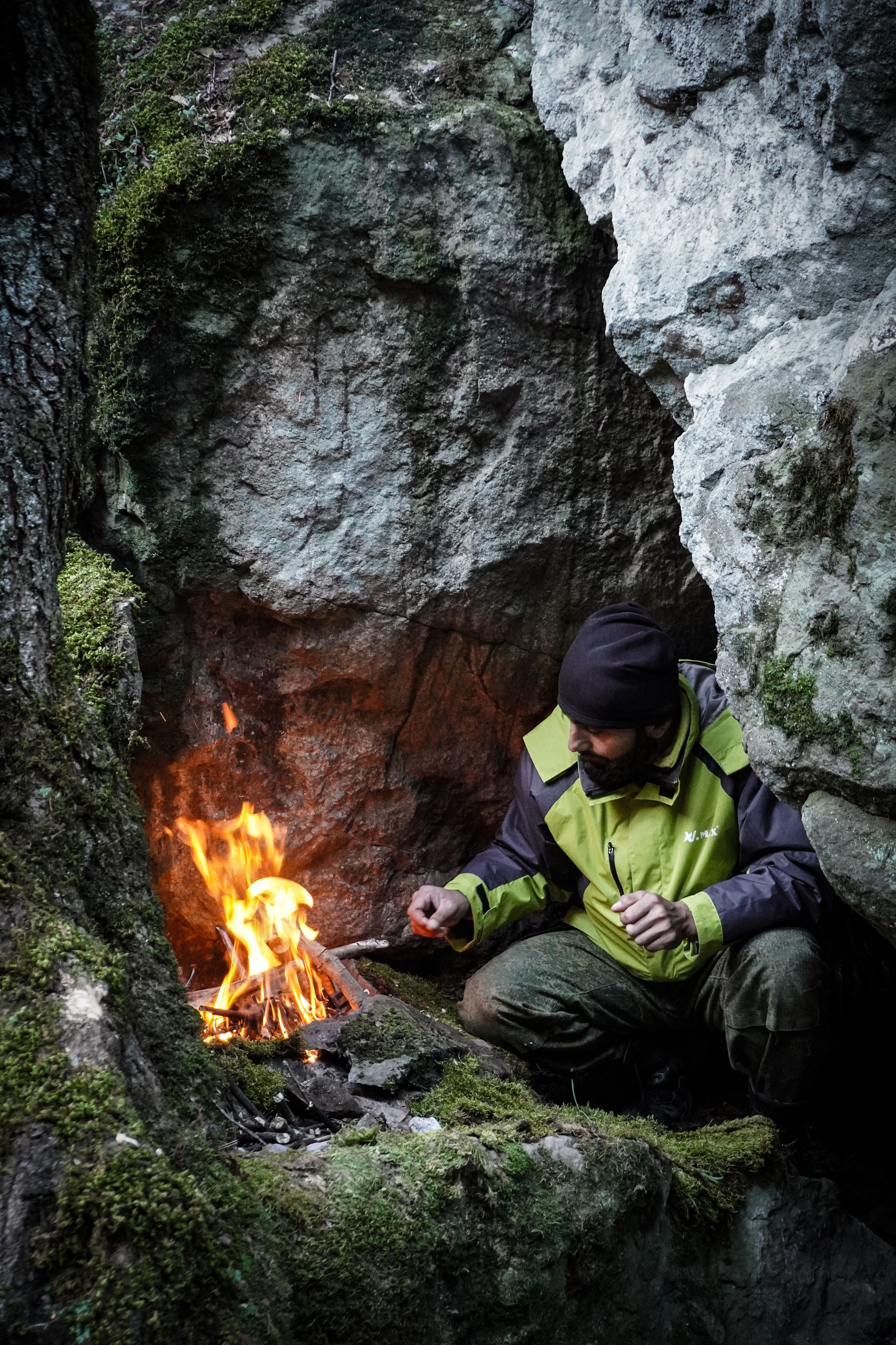 Survivalist Lighting Campfire in Mountain Cave · Free Stock Photo
