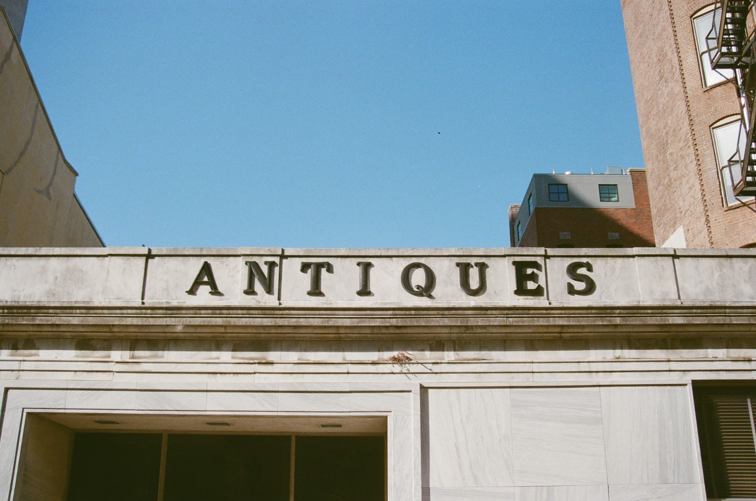 Vintage Antiques Storefront with Clear Blue Sky · Free Stock Photo