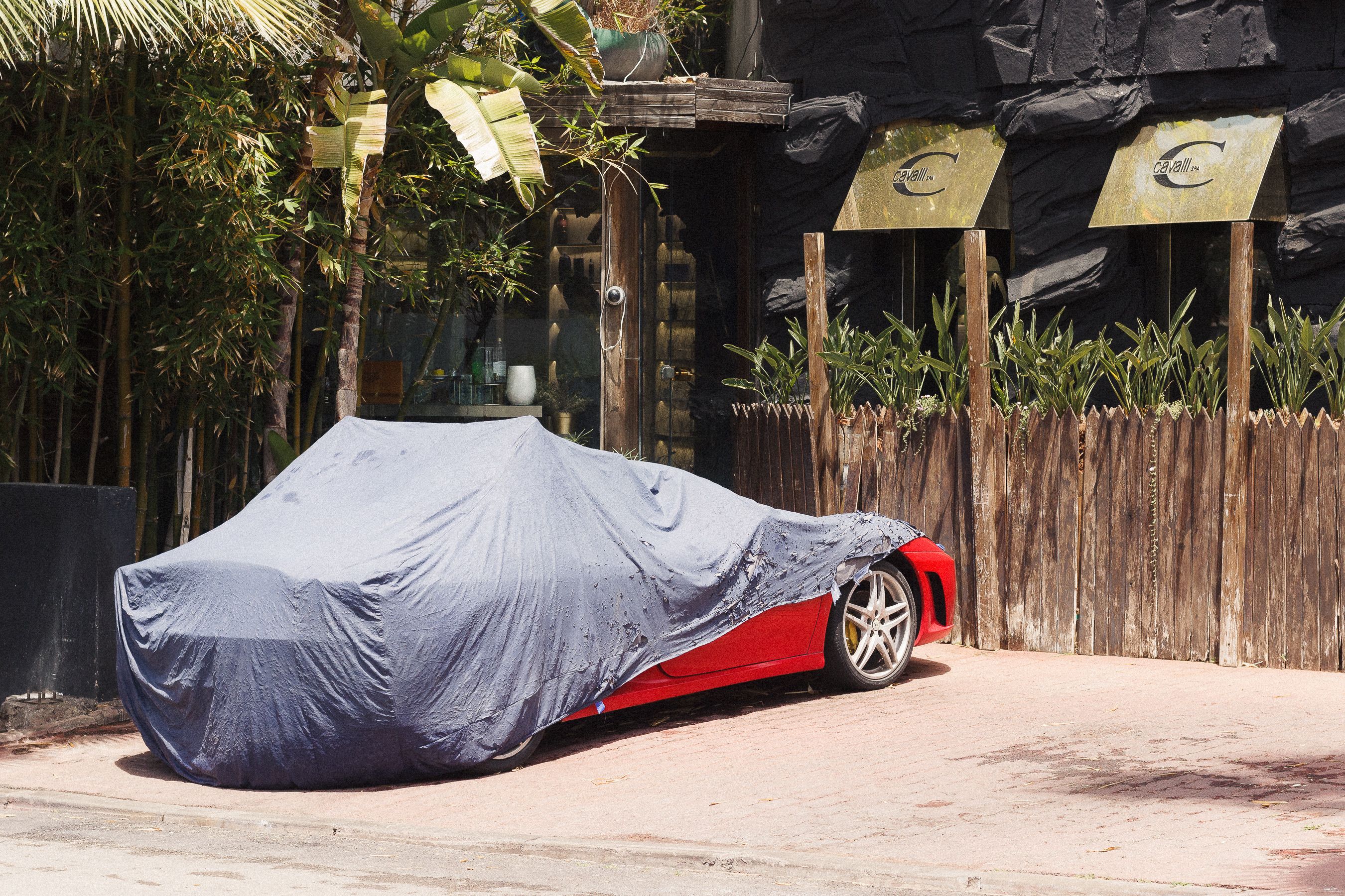 Luxury Car Covered Outdoors in Urban Setting · Free Stock Photo