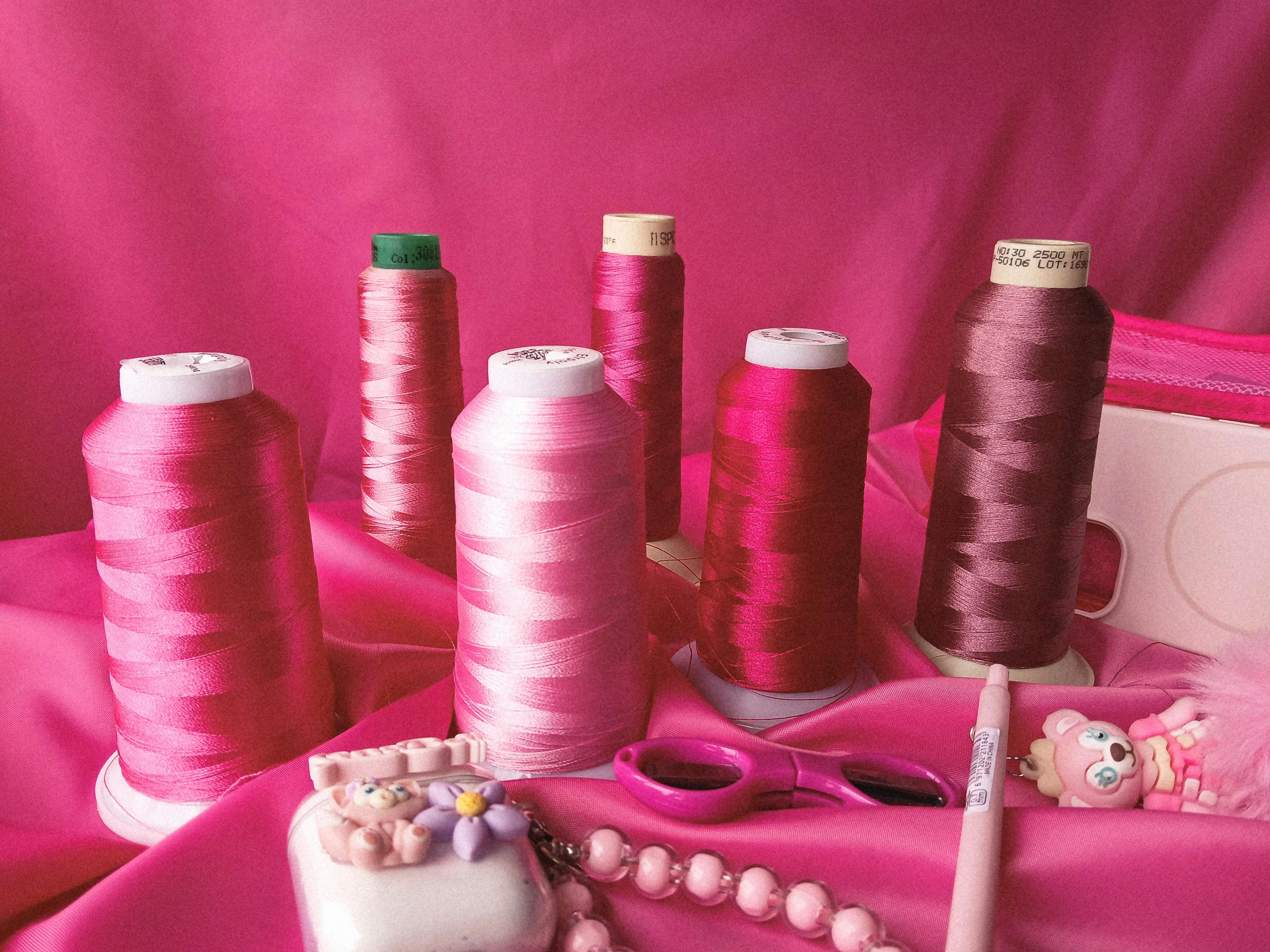 Levendige Roze Naaigarenklossen Op Stof · Gratis stockfoto