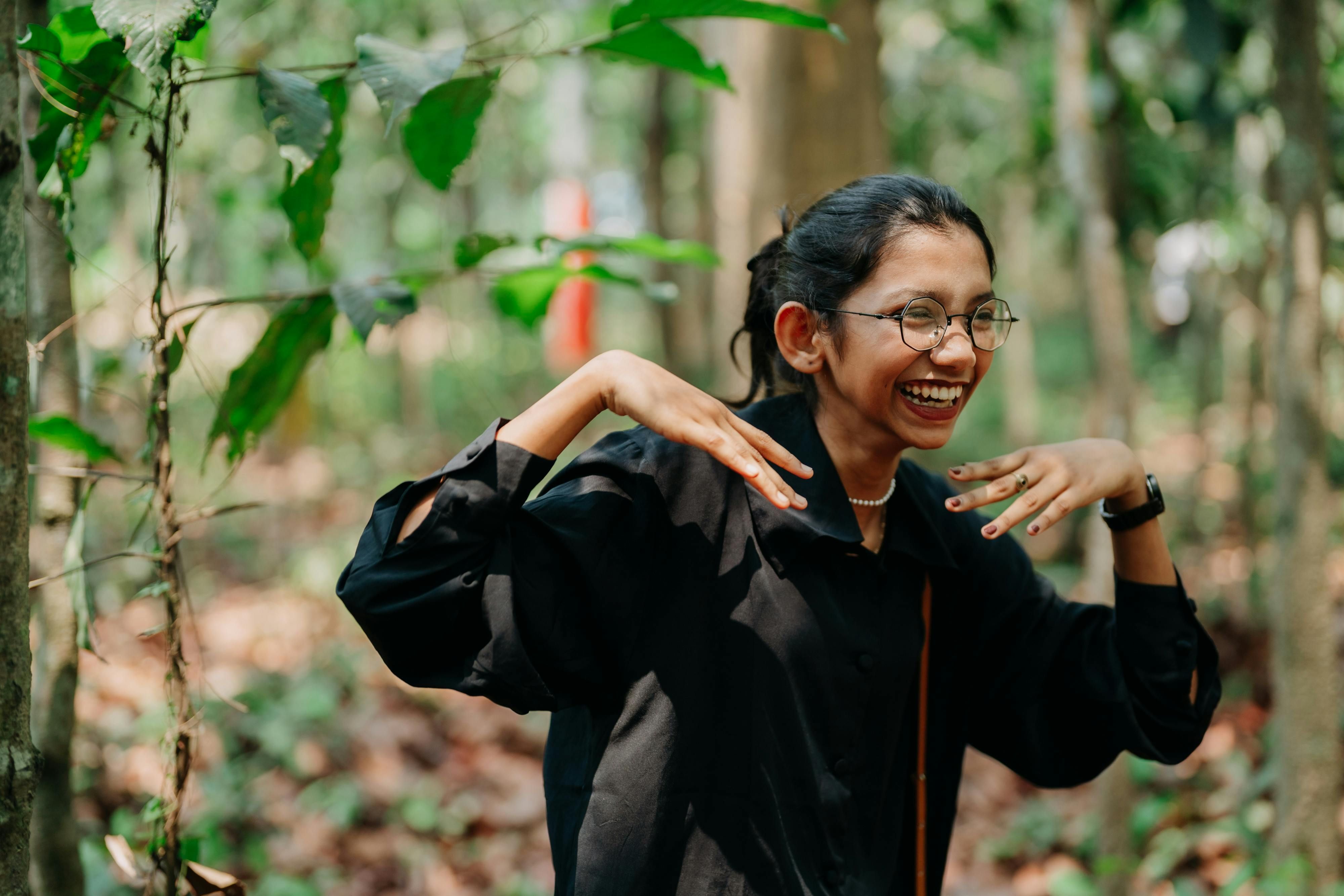 Joyful Woman Laughing in Lush Green Forest Setting · Free Stock Photo