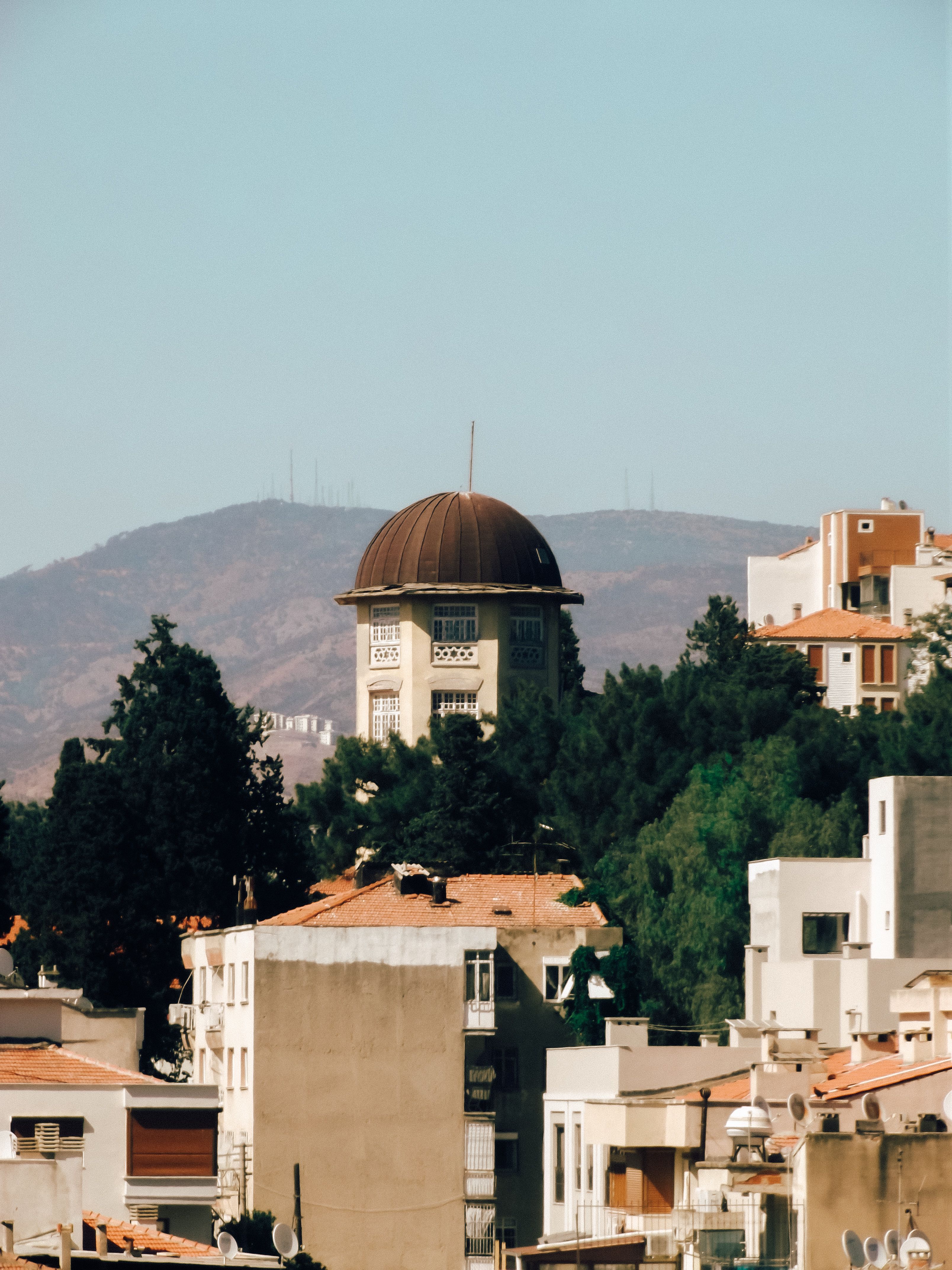 Dome Tower in Urban Landscape with Mountain Backdrop · Free Stock Photo