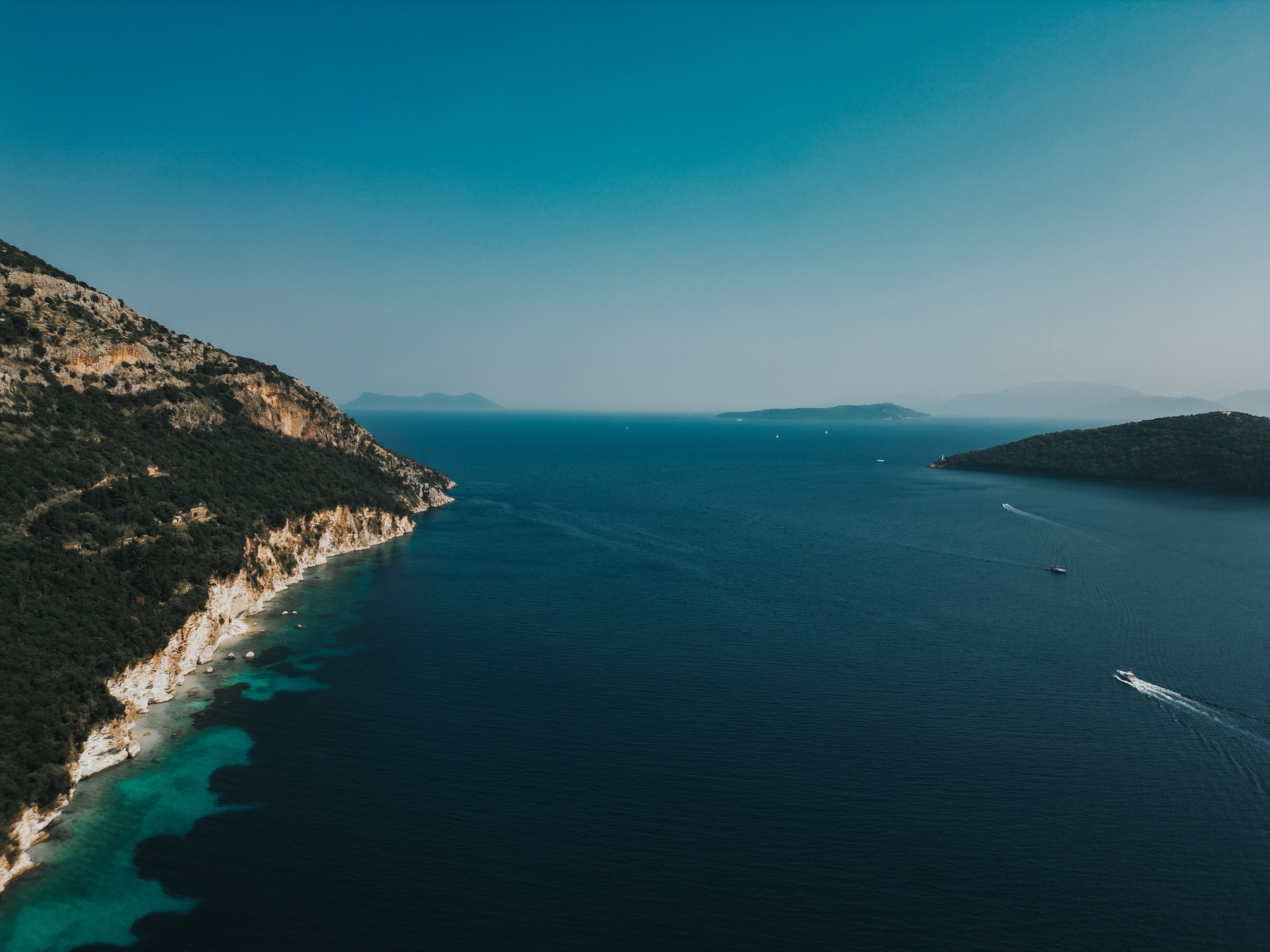Aerial View of Coastal Cliffside and Calm Blue Sea · Free Stock Photo