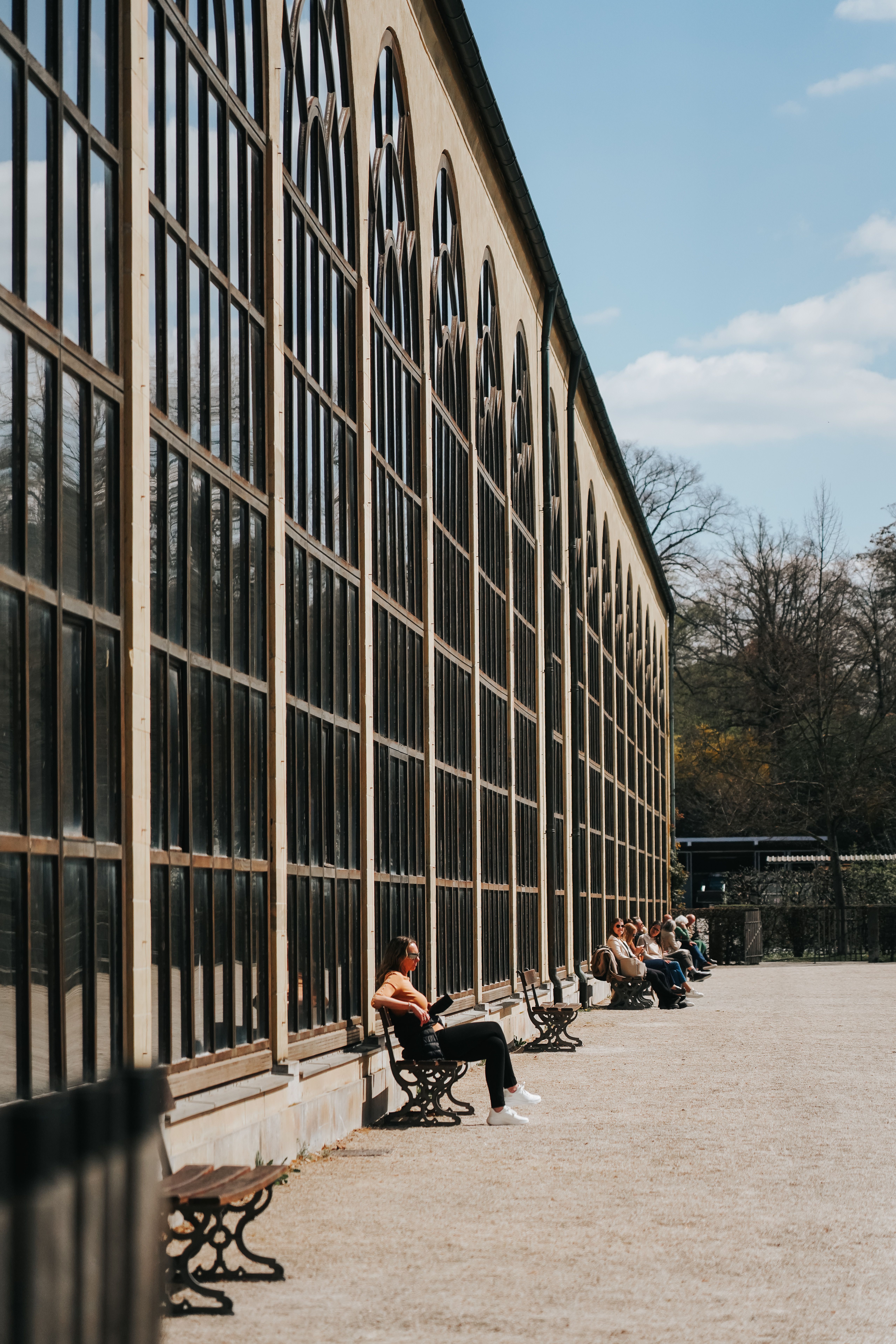 People Relaxing Outside Large Glass Window Building · Free Stock Photo