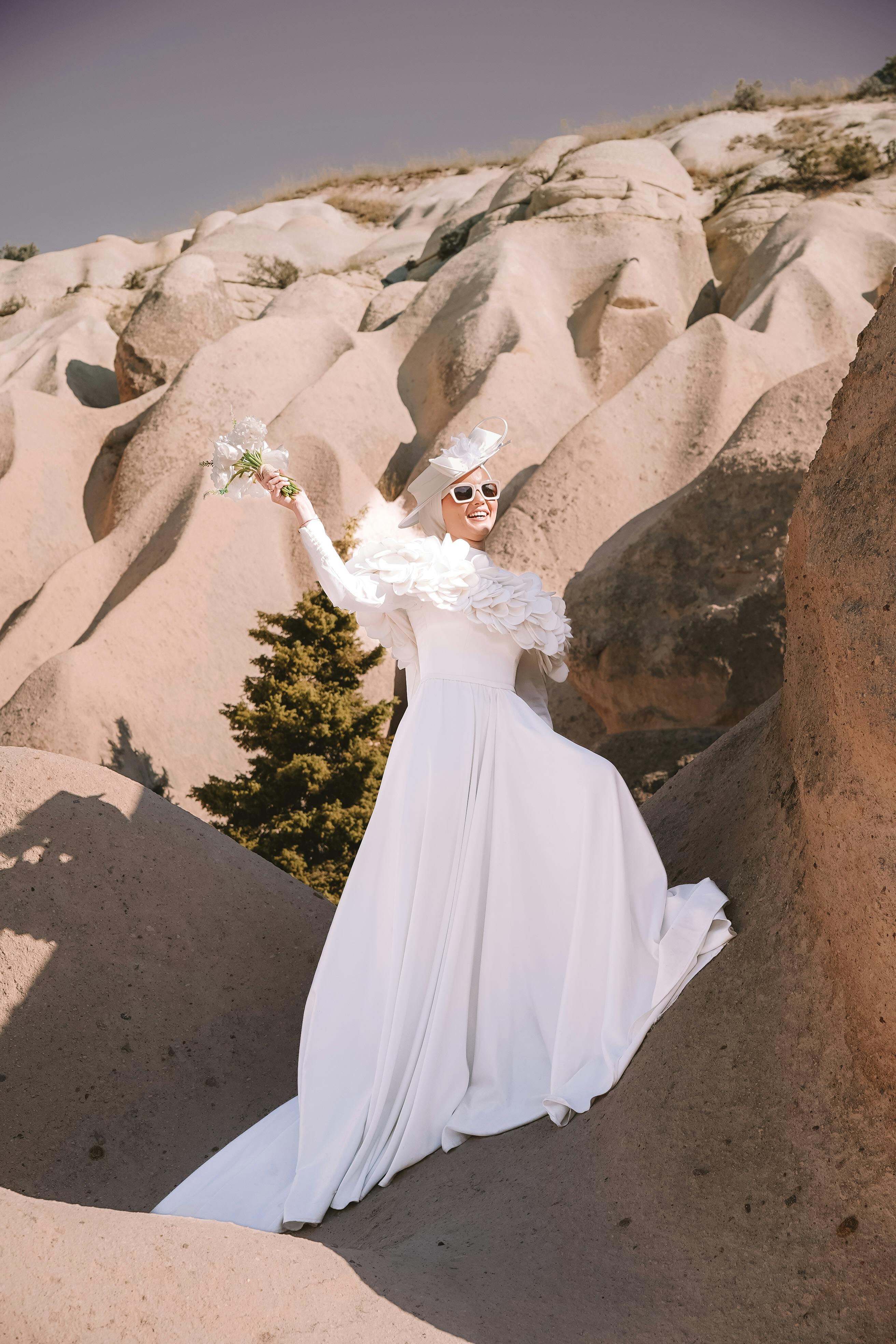 Bride Posing in Wedding Dress Among Rock Formations · Free Stock Photo