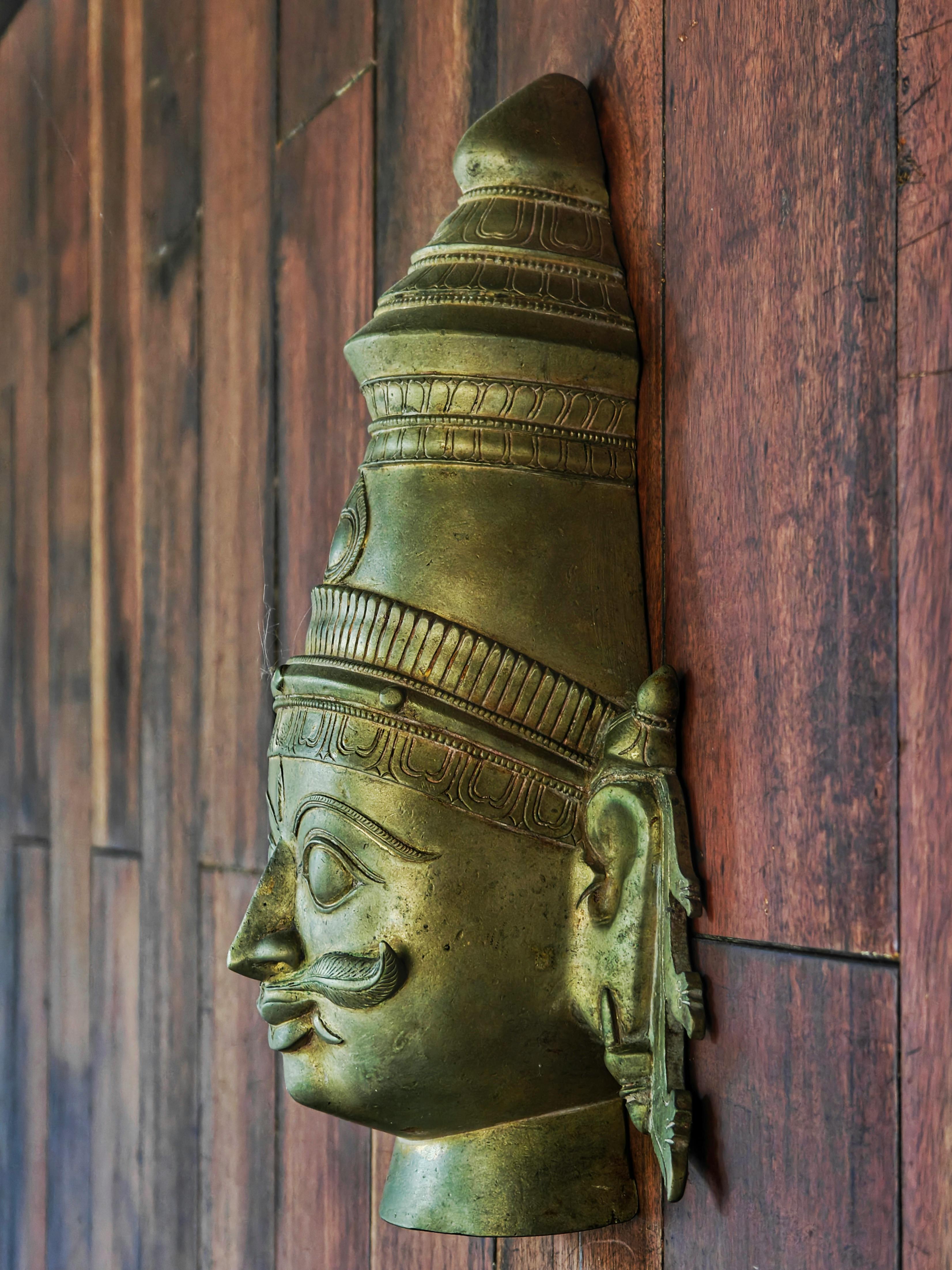 Traditional Brass Relief Sculpture on Wooden Wall · Free Stock Photo