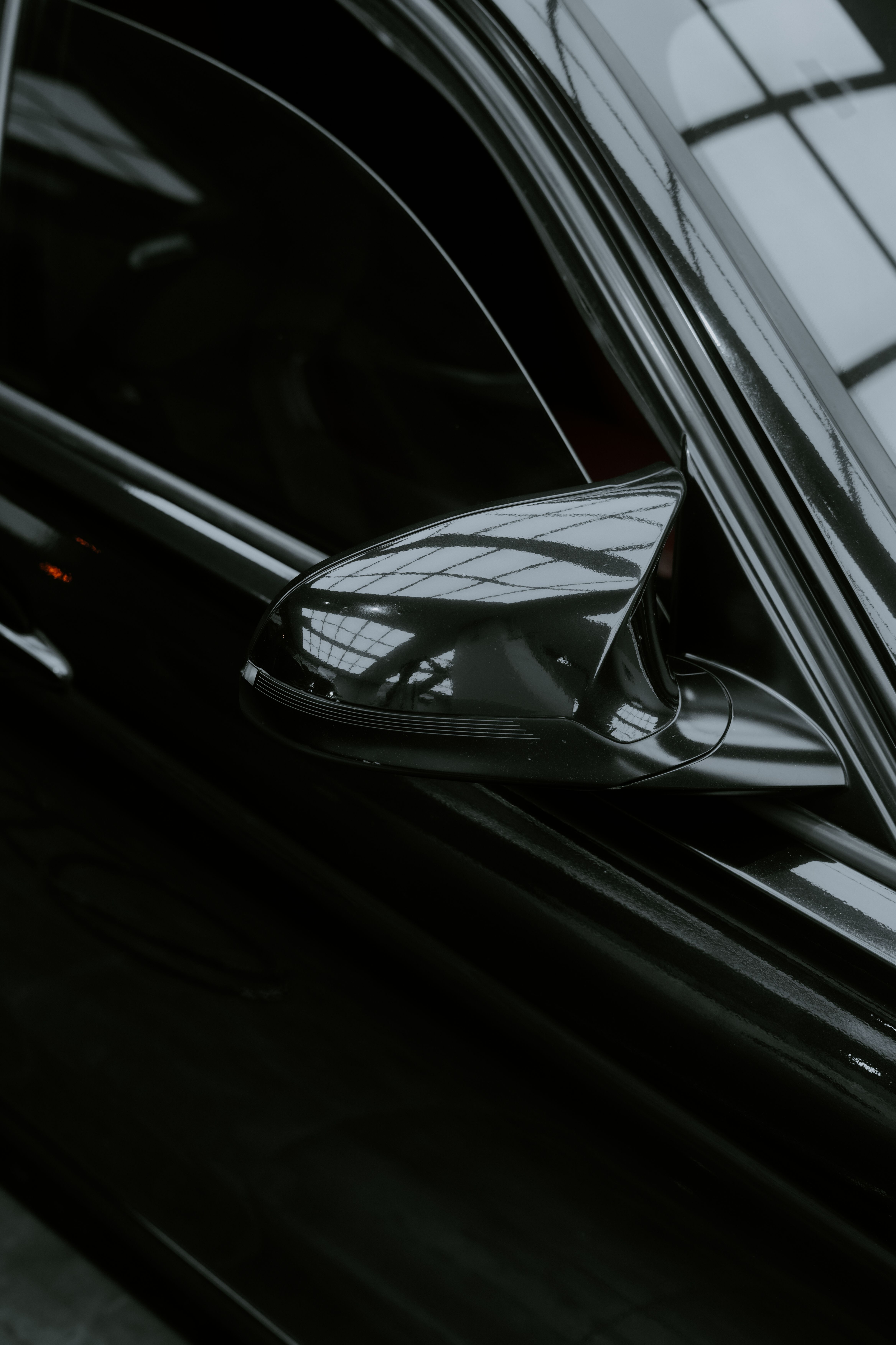 Close-up of a sleek black car mirror with reflections · Free Stock Photo