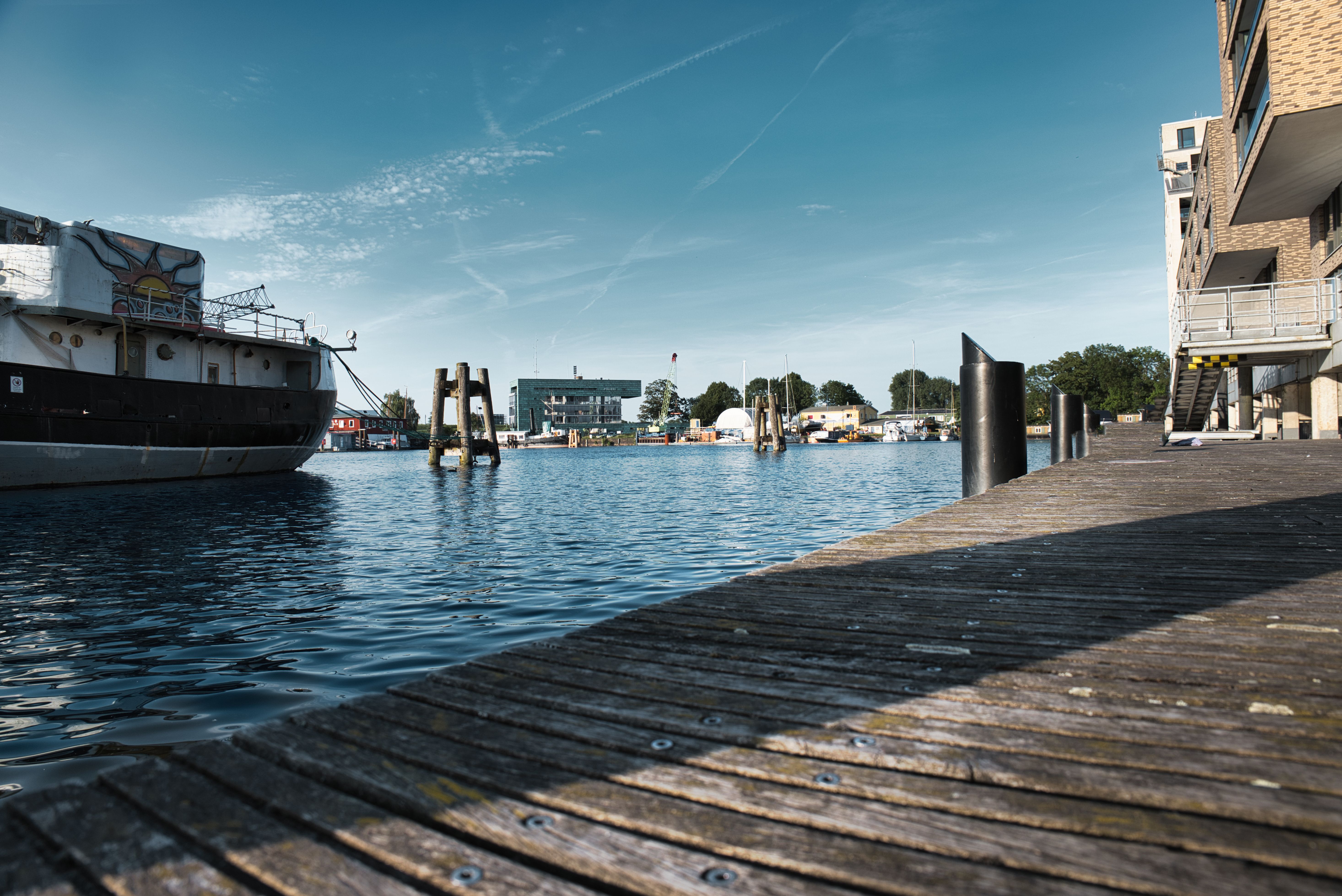 Scenic Waterfront with Boat Docked at Marina · Free Stock Photo