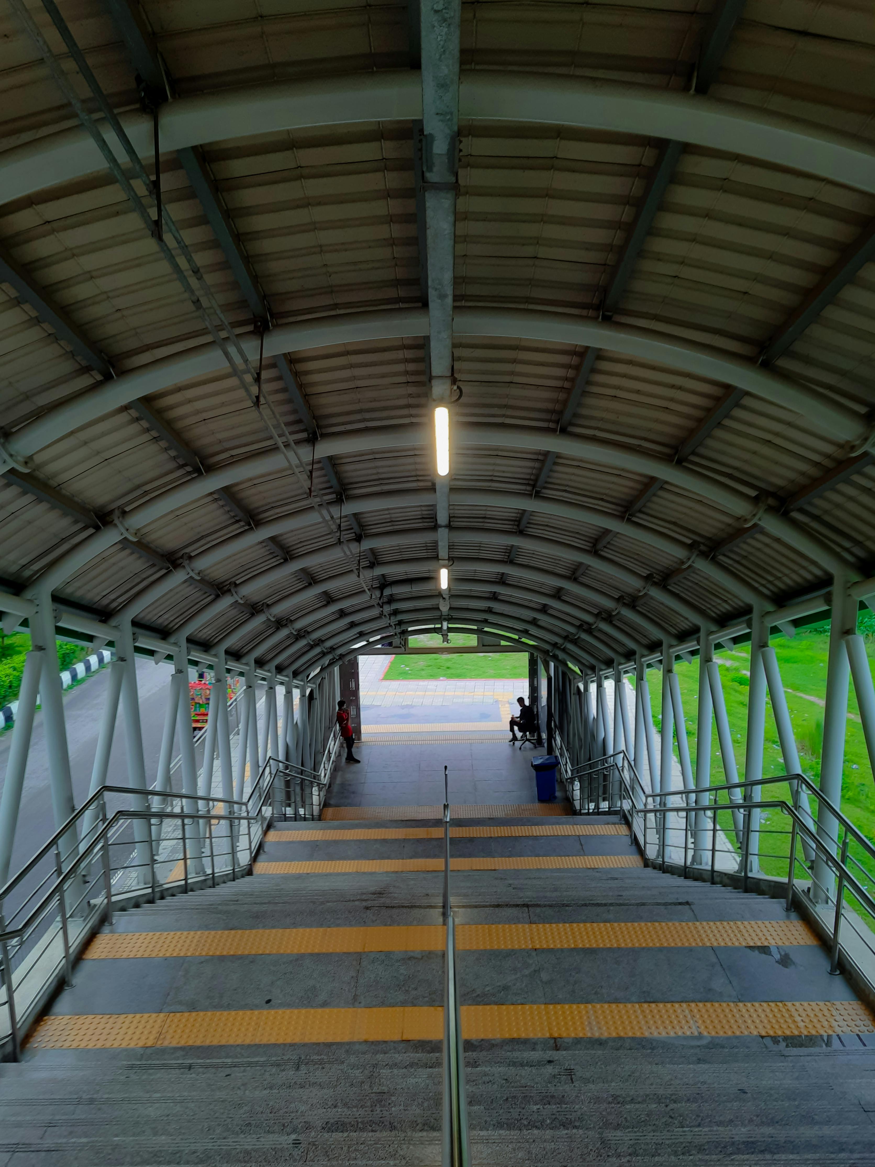 Covered Pedestrian Bridge with Stairs and Green Surroundings · Free ...