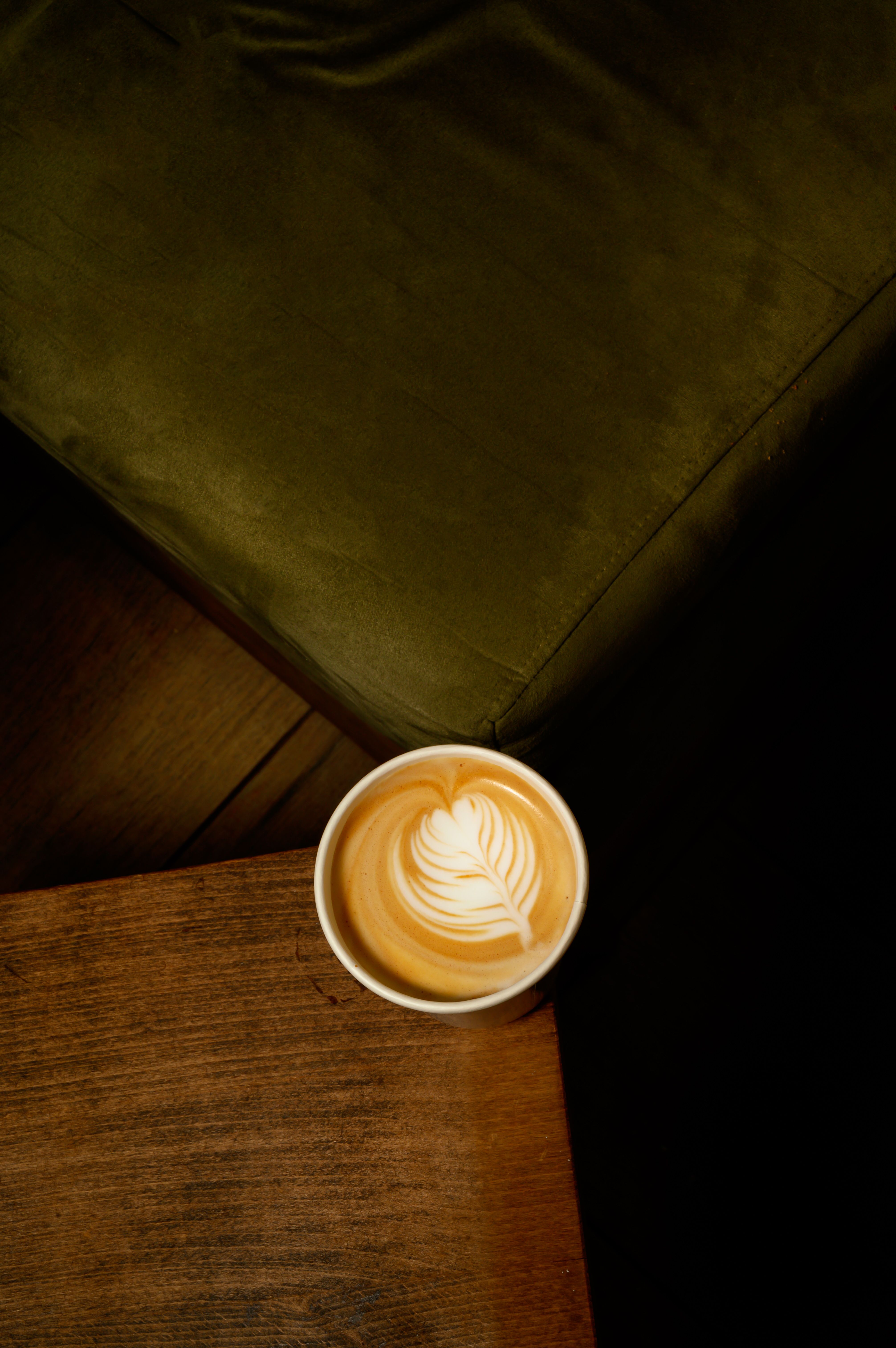 Latte art in cup of coffee on a Round Table · Free Stock Photo