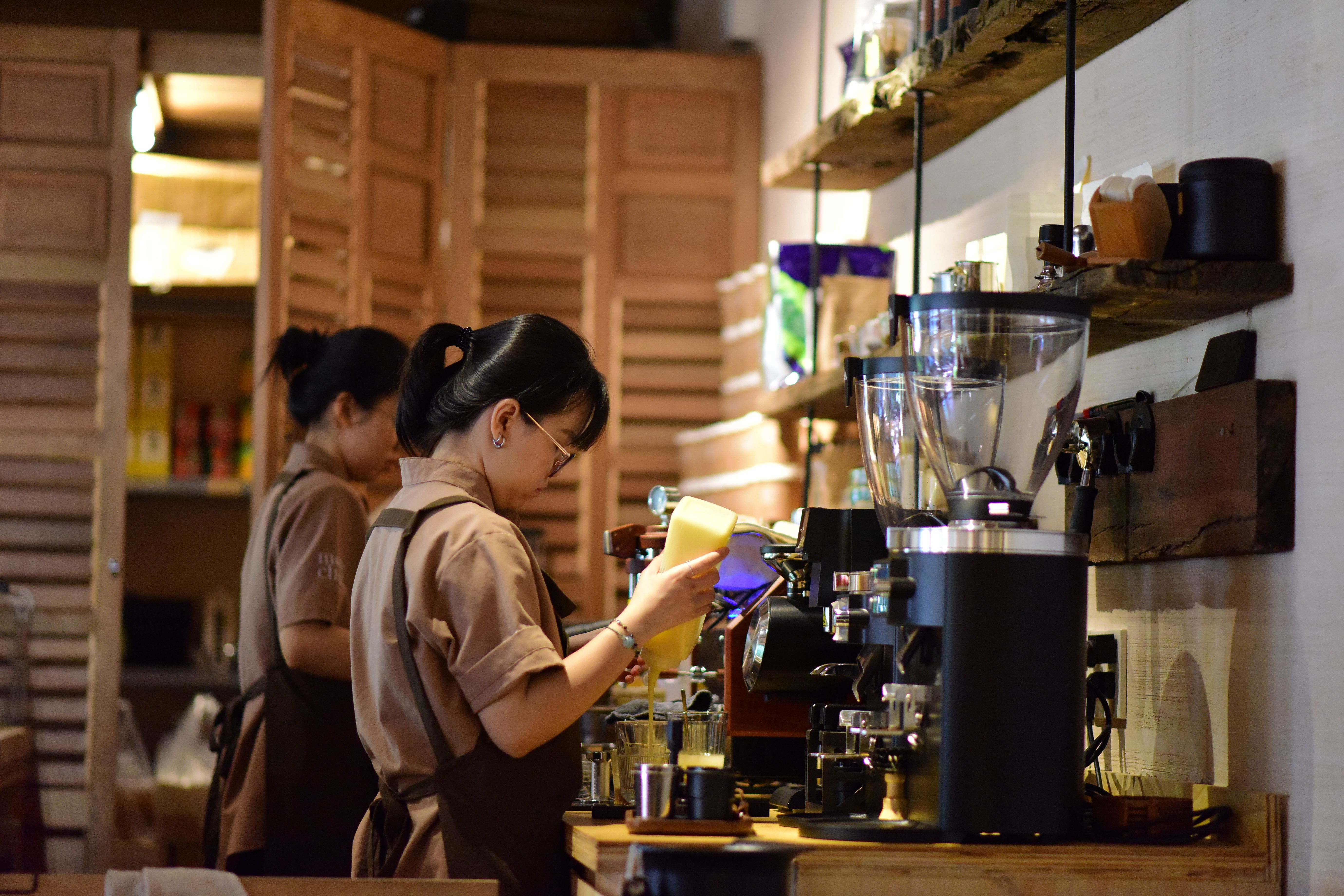Cheerful female barista serving coffee to client · Free Stock Photo