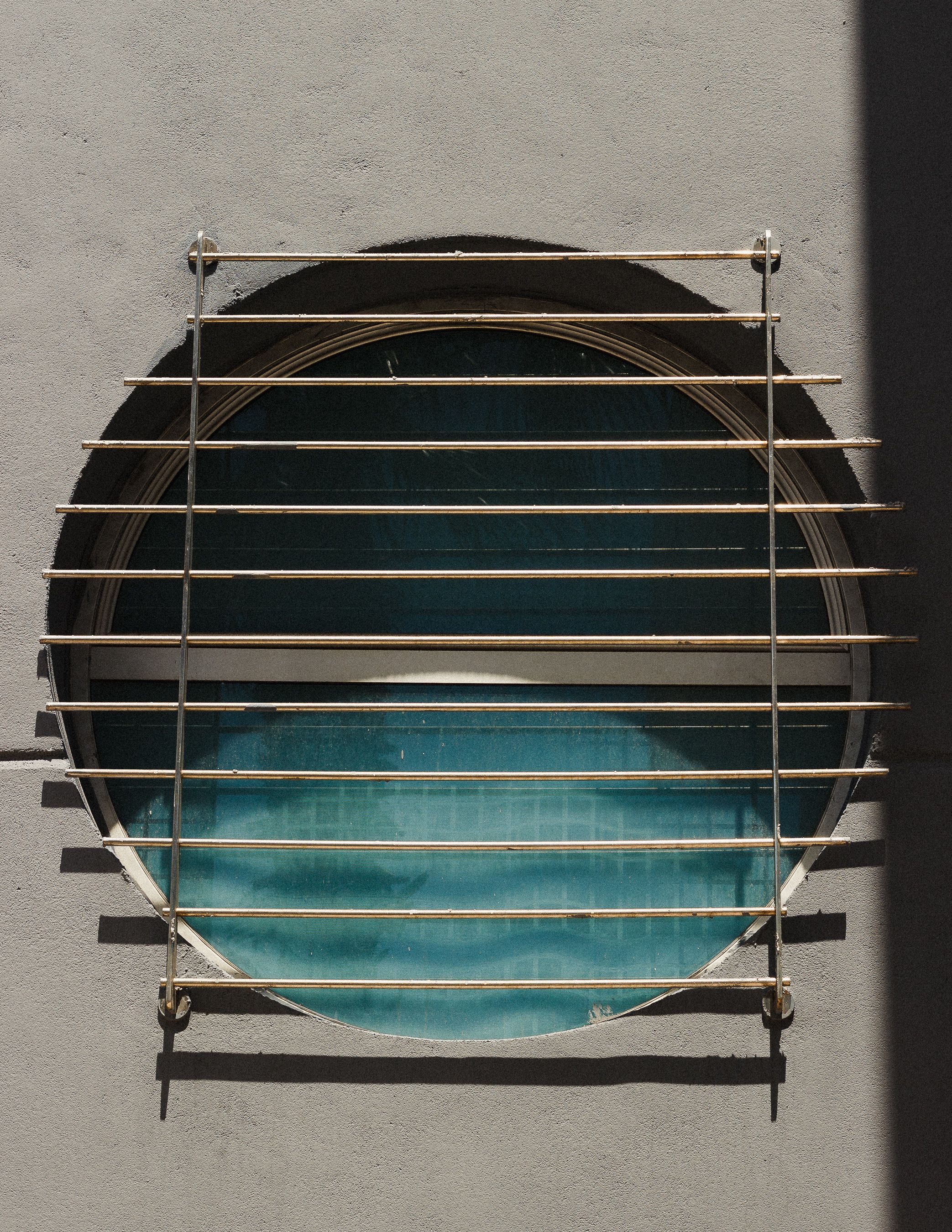 Circular Window with Metal Bars in Sunlight · Free Stock Photo