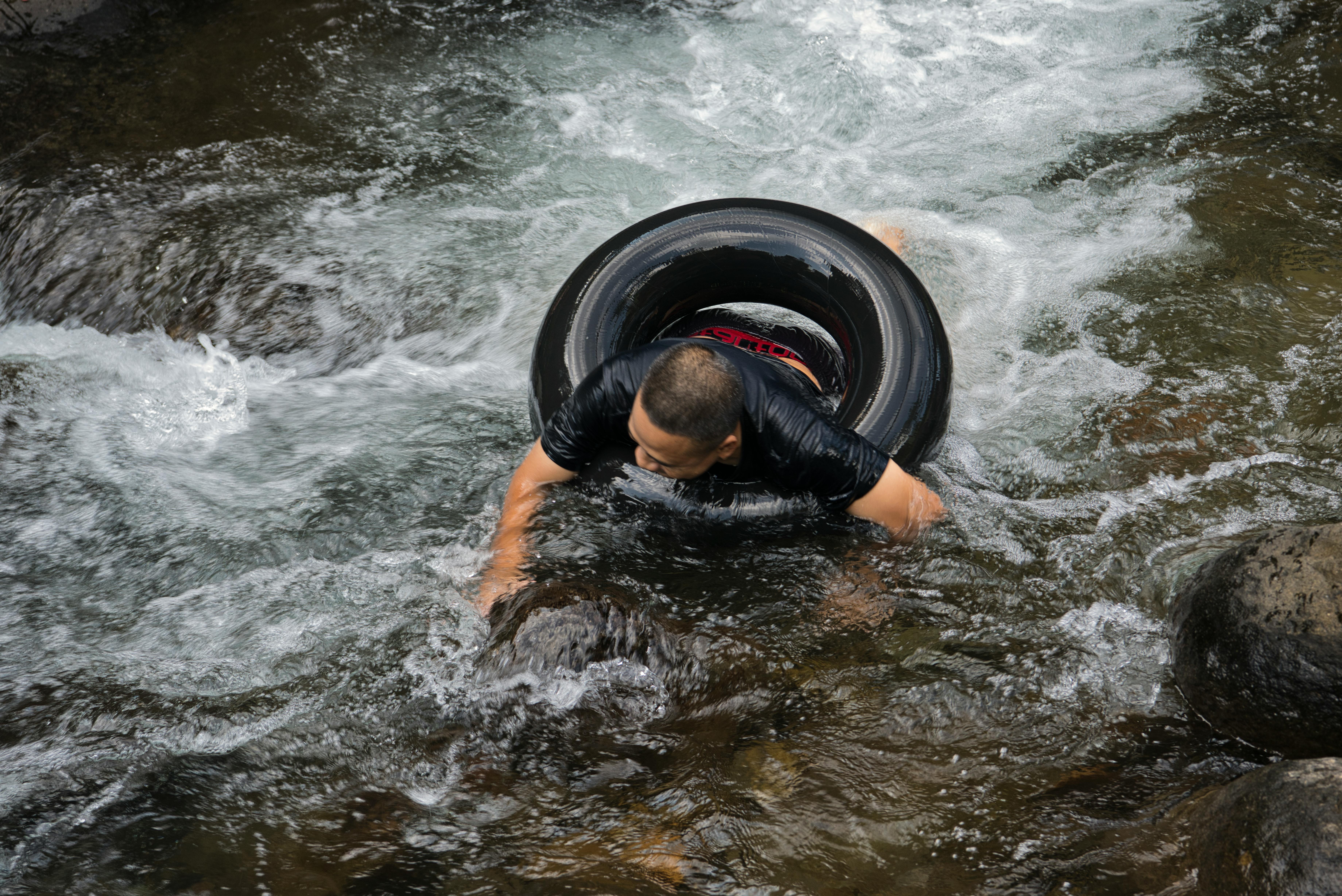 Man Tubing Down a Rocky River for Adventure · Free Stock Photo