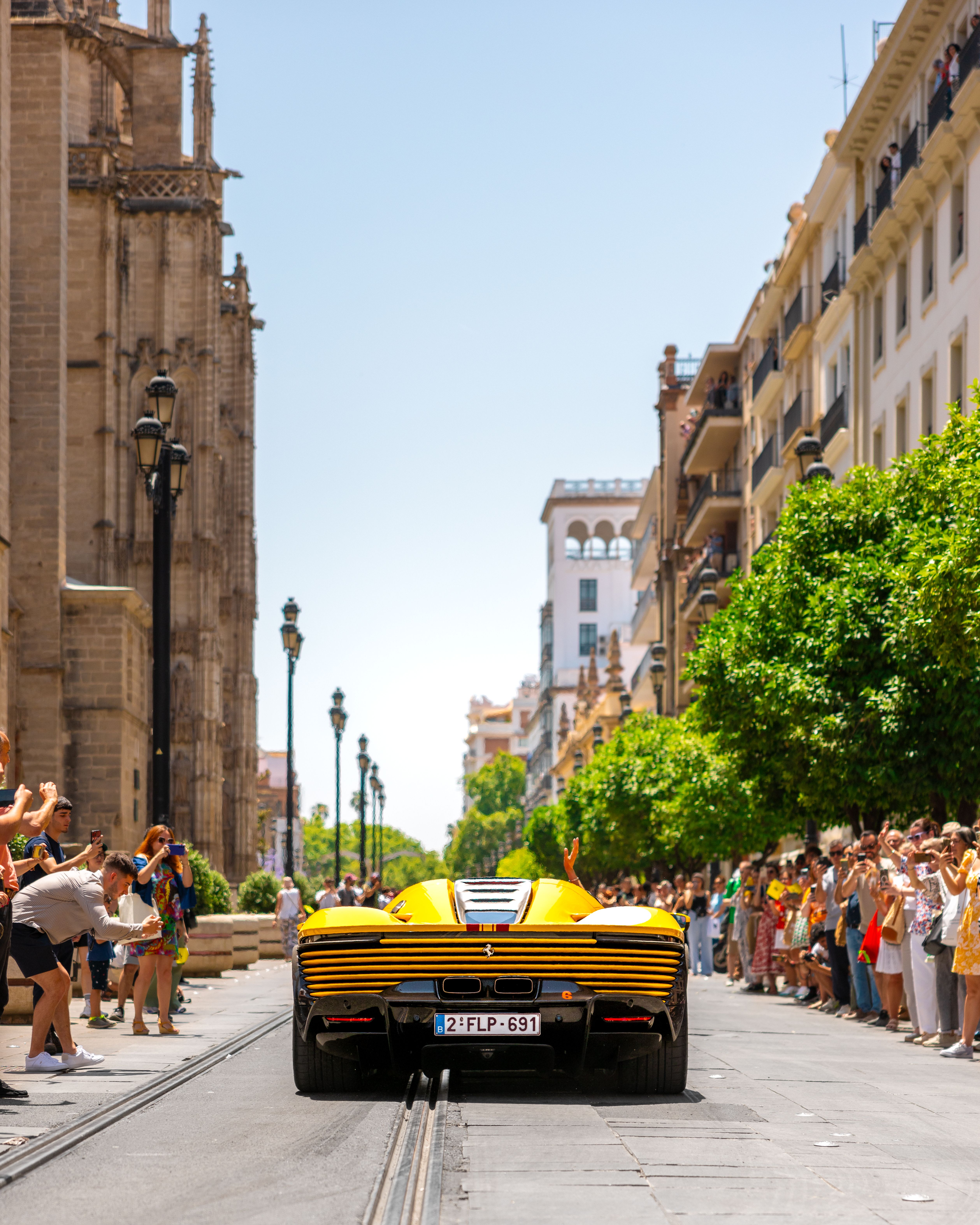Vibrant Street Scene with Yellow Sports Car in Seville · Free Stock Photo