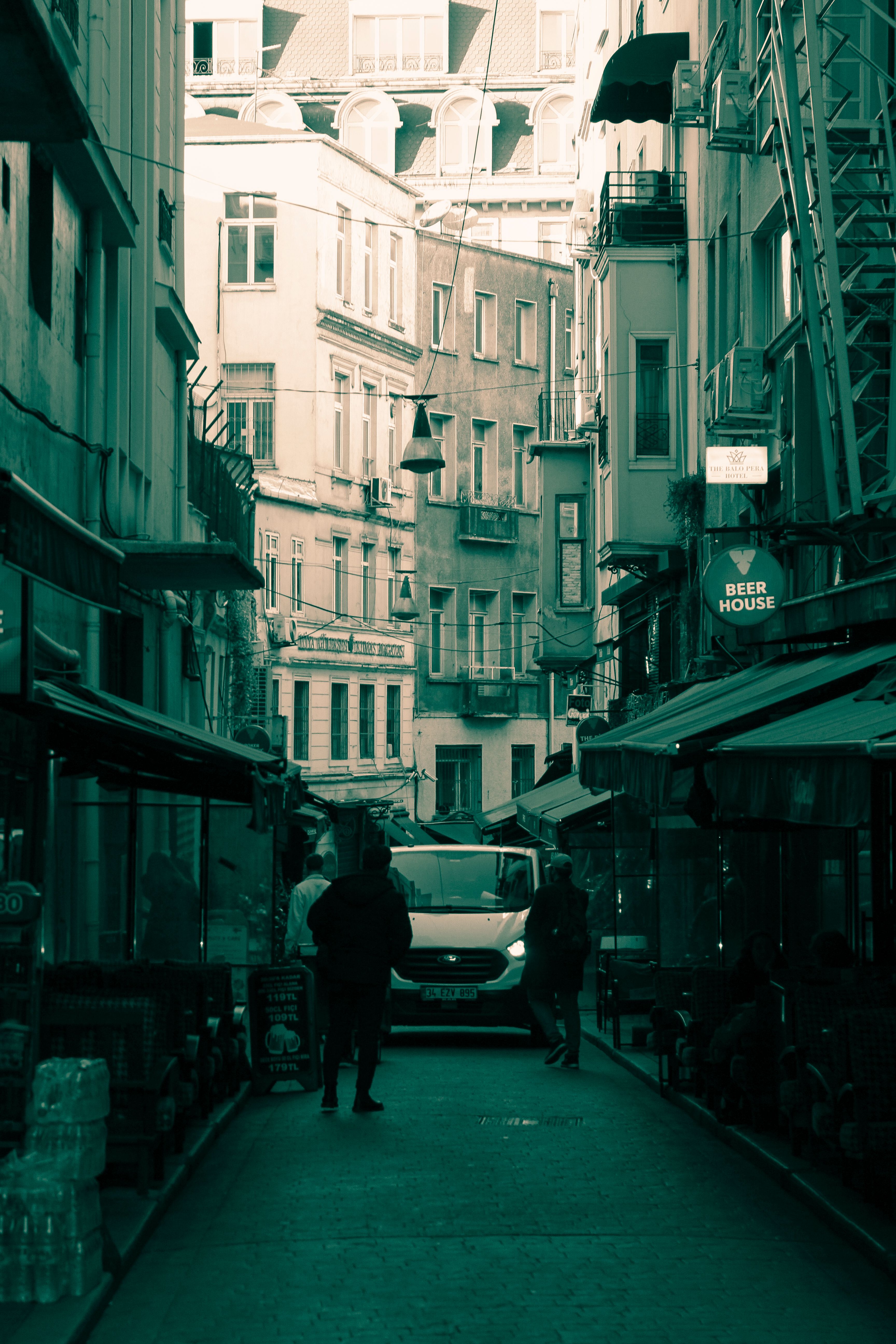 Back View of a Man in a Hat Walking on a Crowded Street in City · Free ...