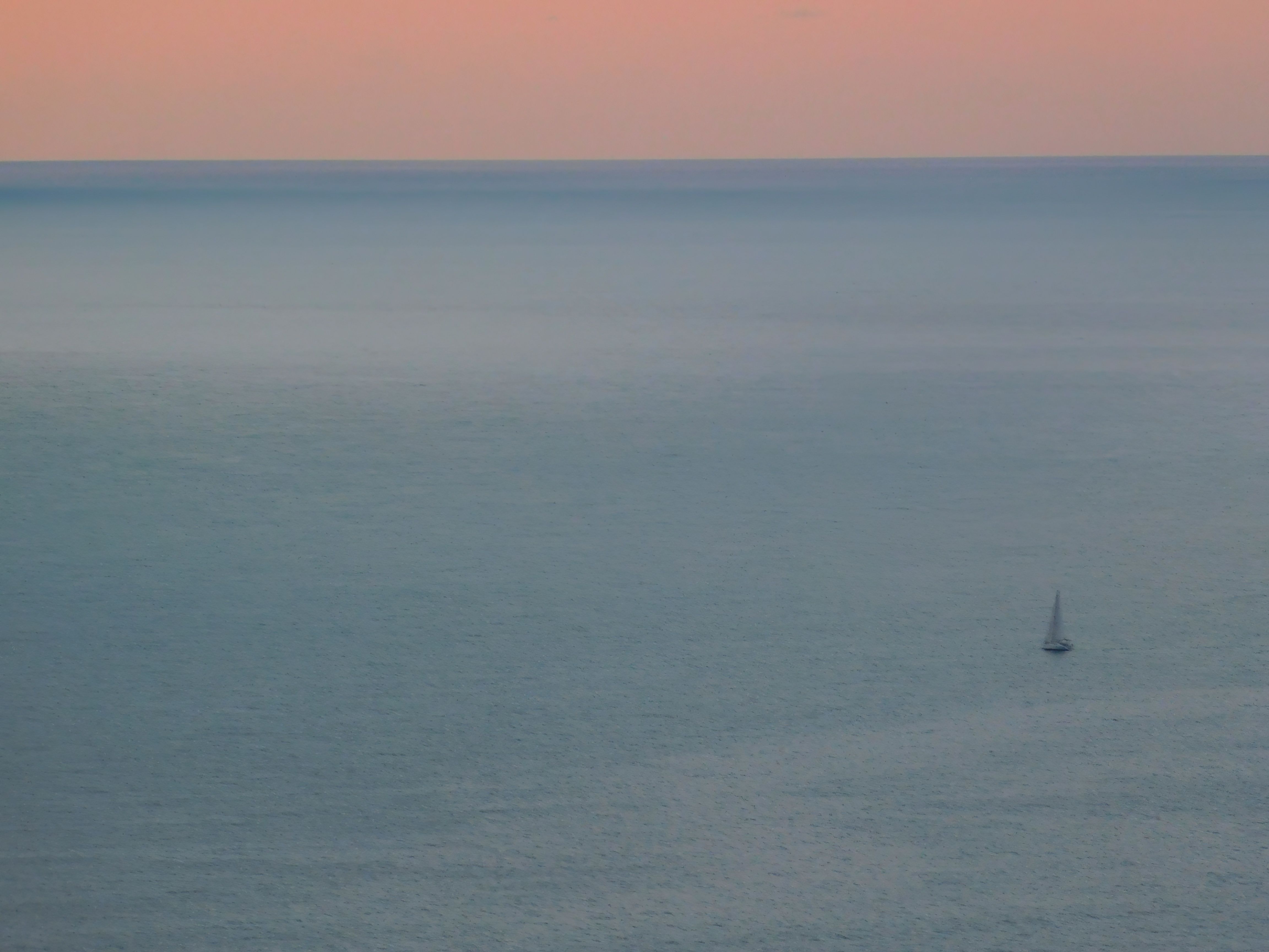 Serene Ocean View with Distant Sailboat at Sunset · Free Stock Photo