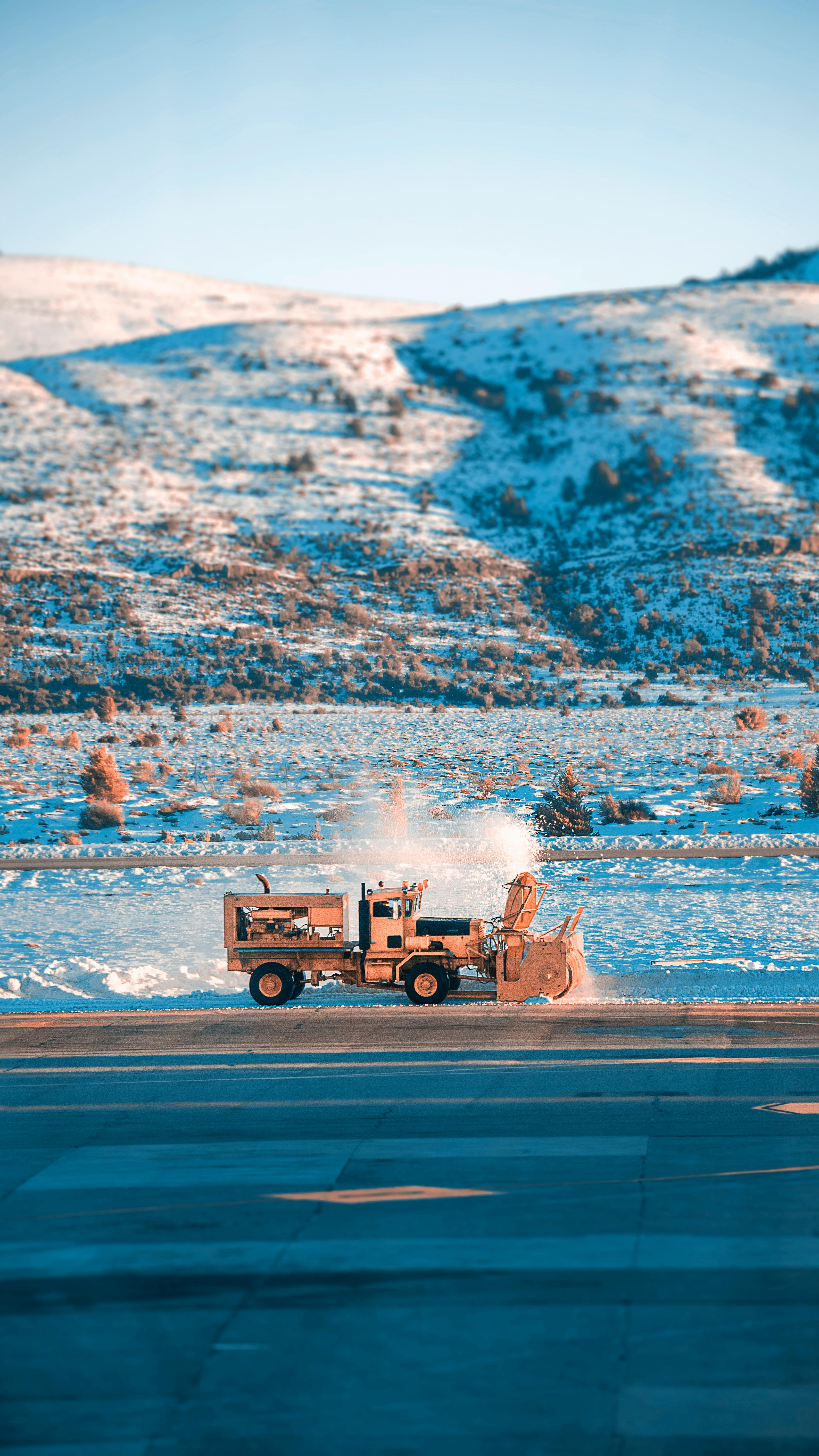Orange and Black Tractor Next to Piles of Rocks · Free Stock Photo
