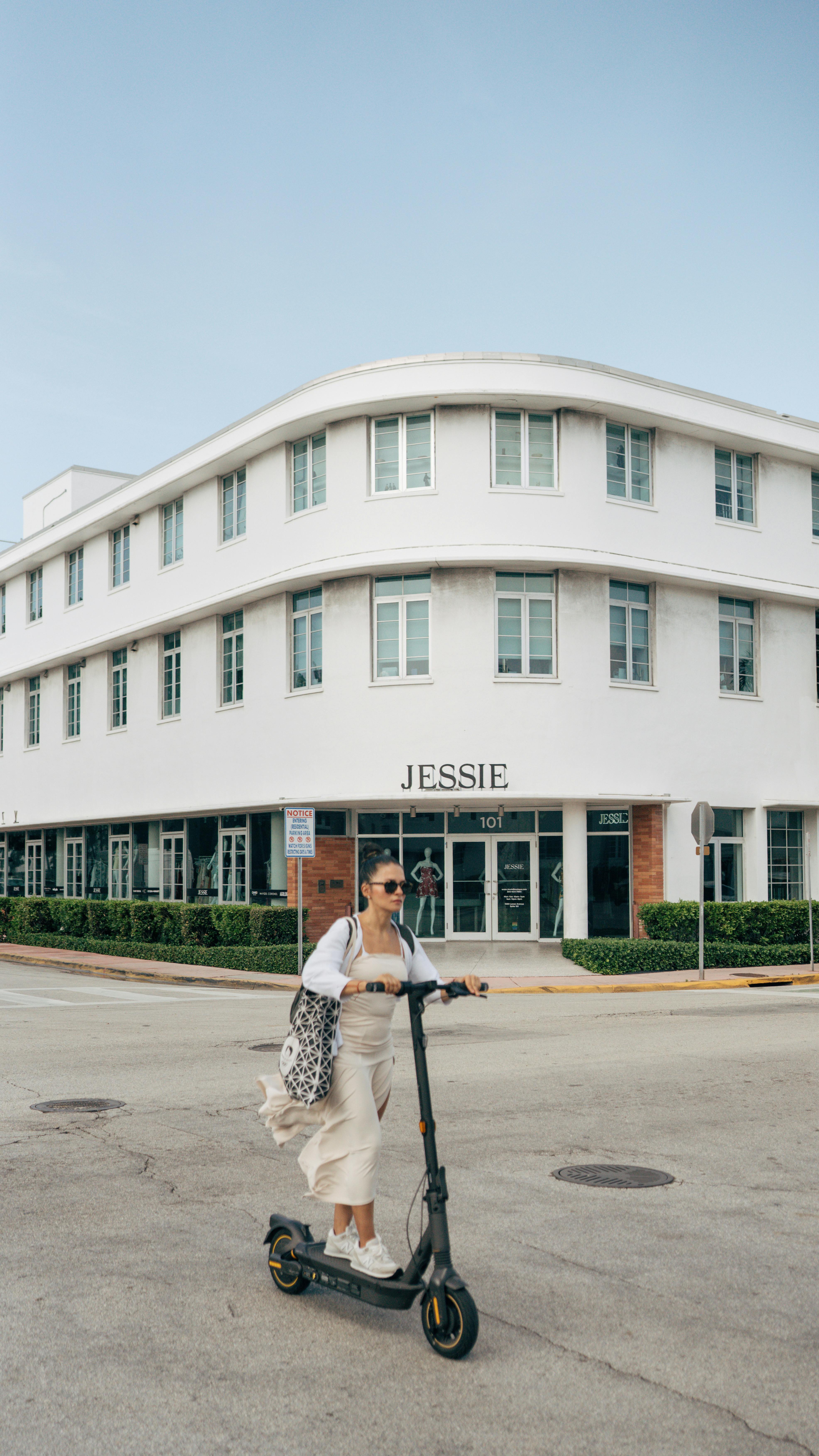Woman Riding Scooter Outside Art Deco Building · Free Stock Photo