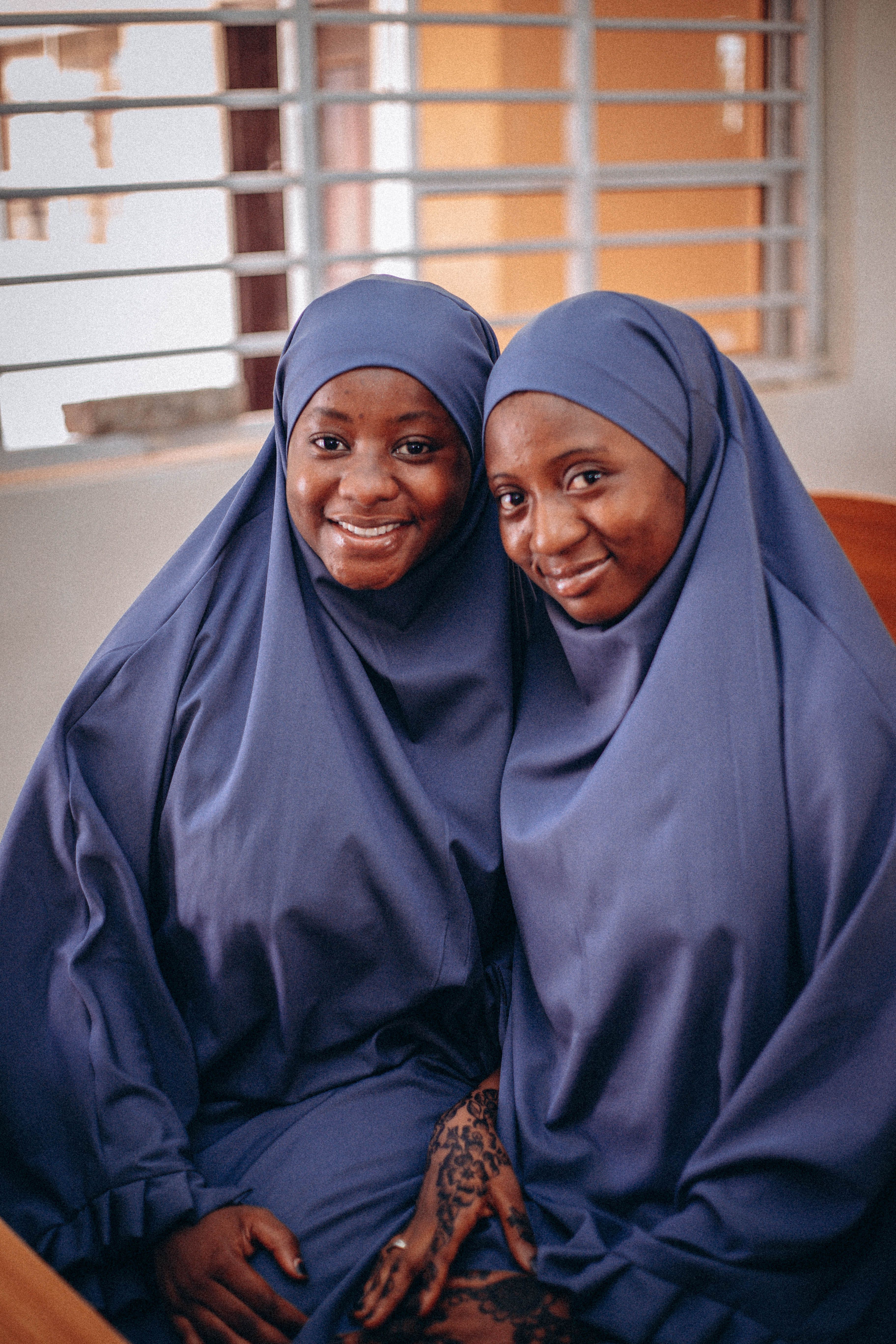 Portrait of Two Women in Blue Hijabs Indoors · Free Stock Photo