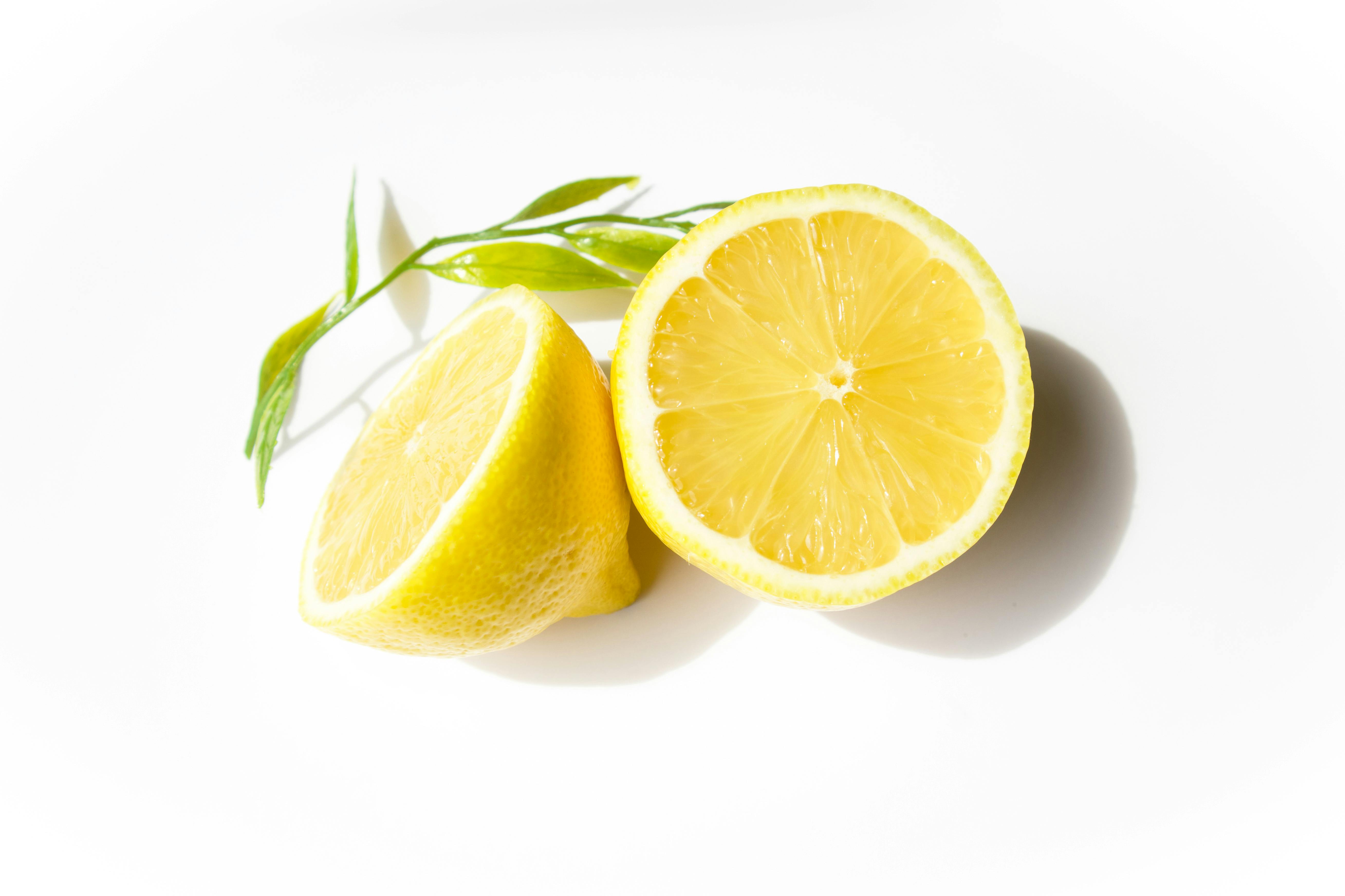 Fresh Sliced Lemon with Green Leaf on White Background · Free Stock Photo
