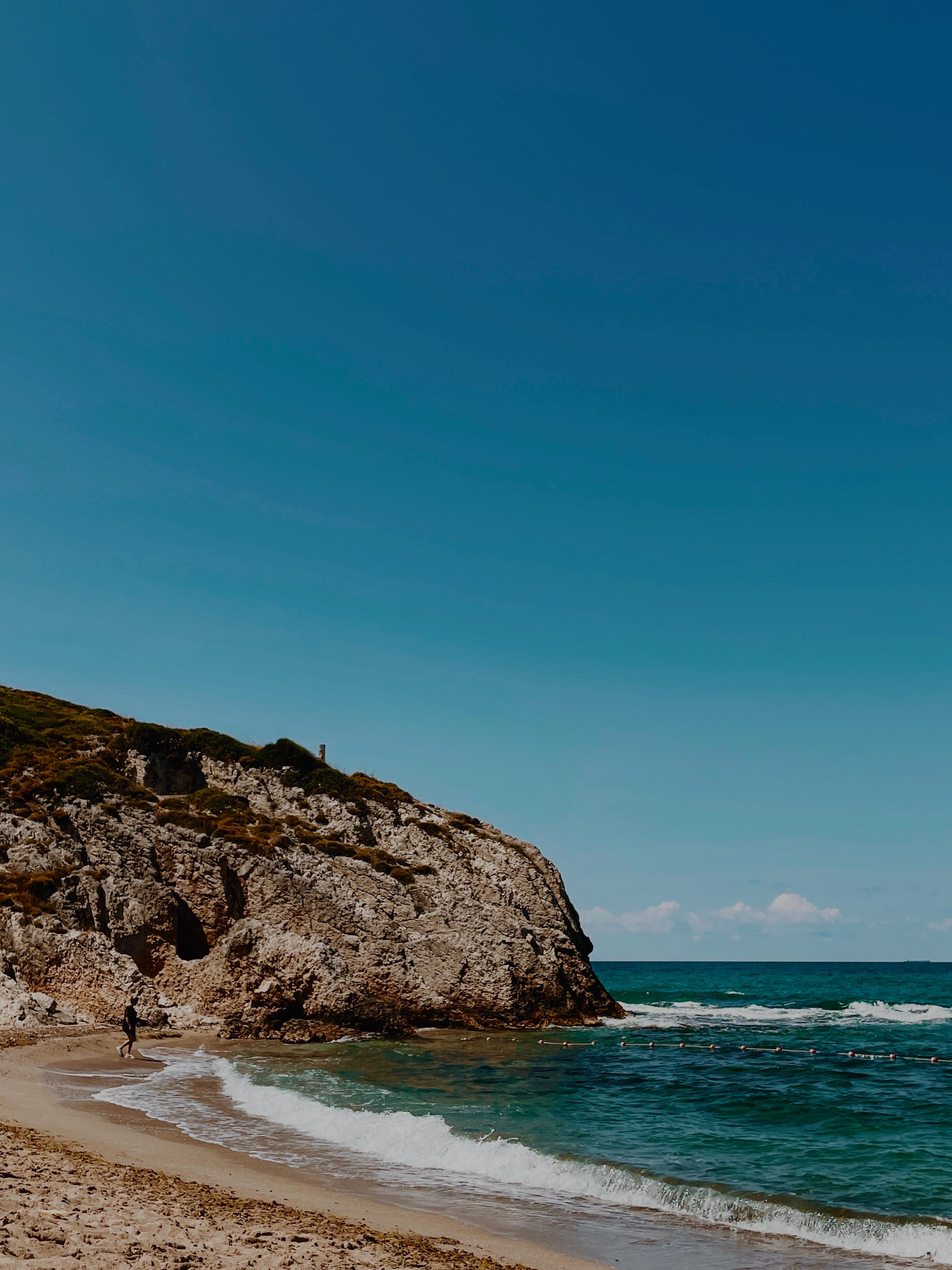 Serene Beach Scene with Cliffside Landscape · Free Stock Photo