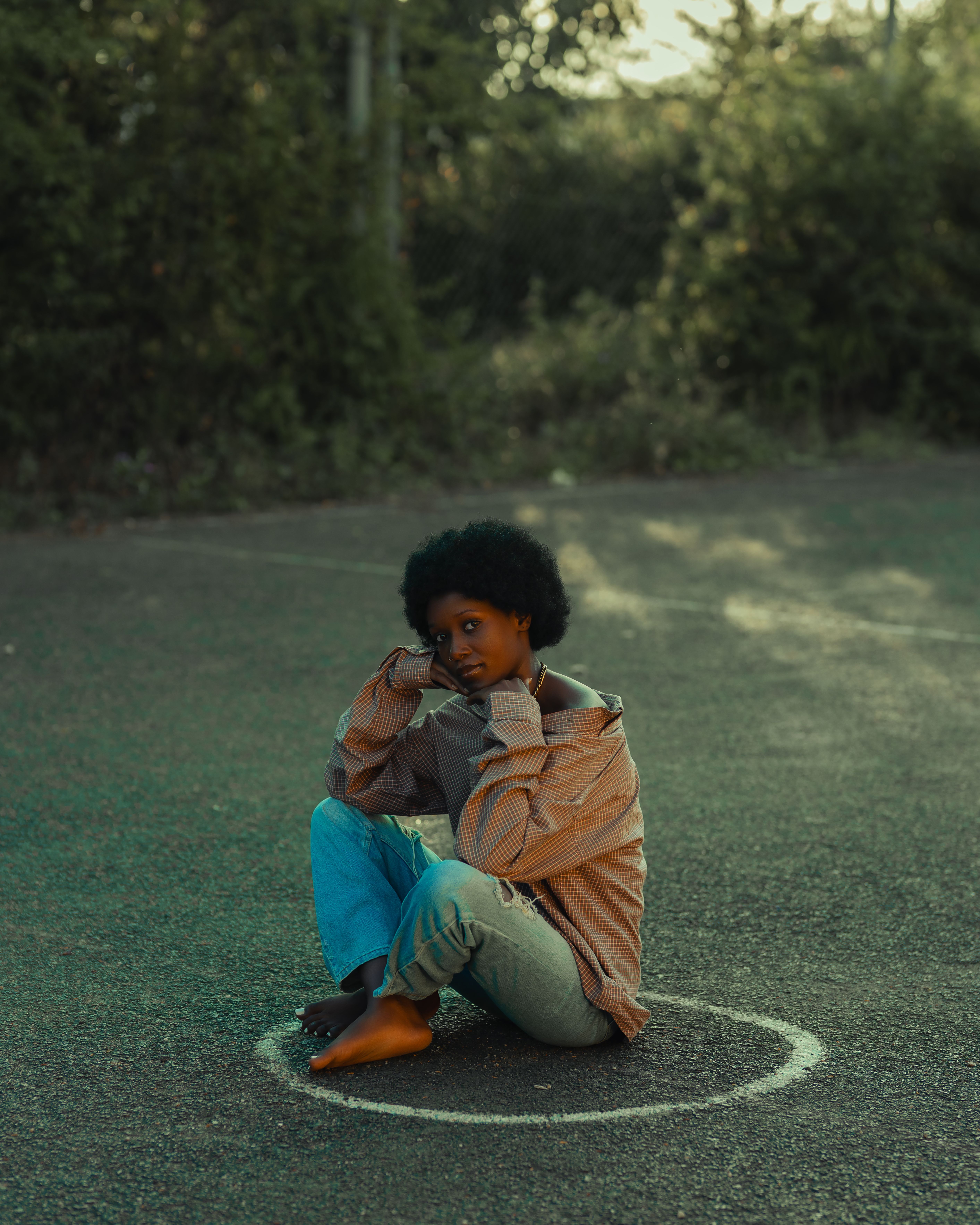 Young Person Sitting Outdoors on Pavement · Free Stock Photo