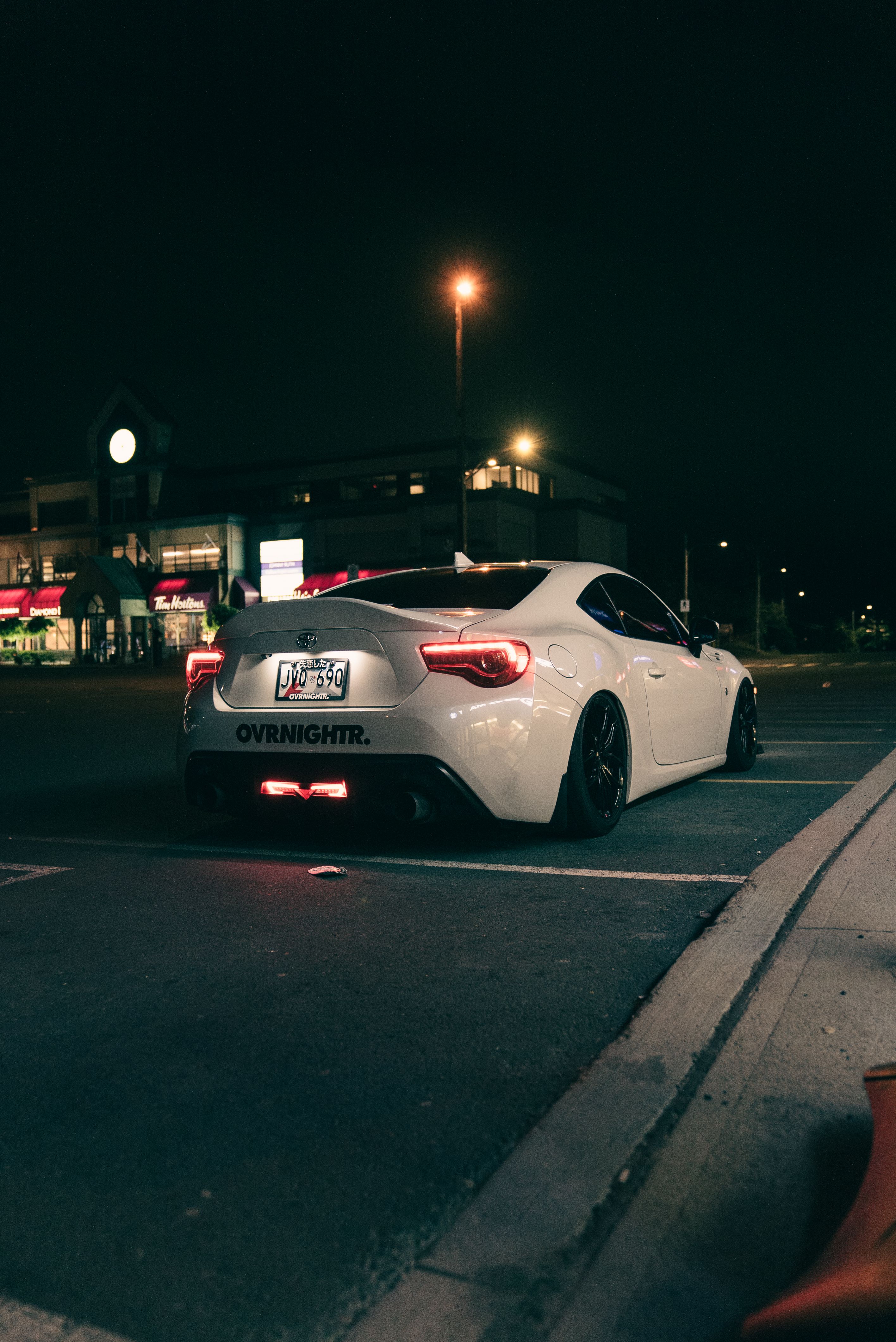 Sleek White Car in Empty Night Parking Lot · Free Stock Photo