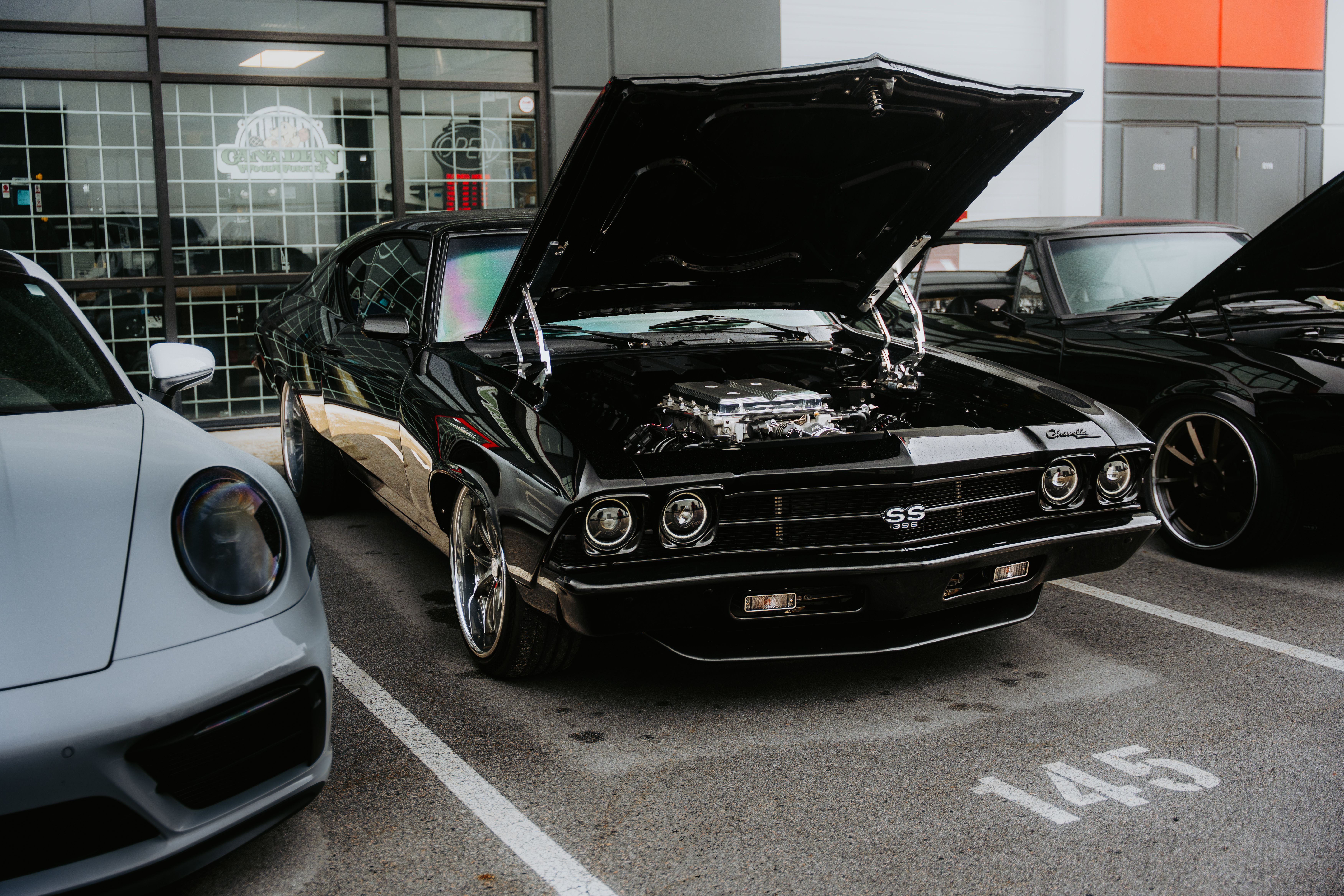 Classic Car Display with Open Hood in Parking Lot · Free Stock Photo