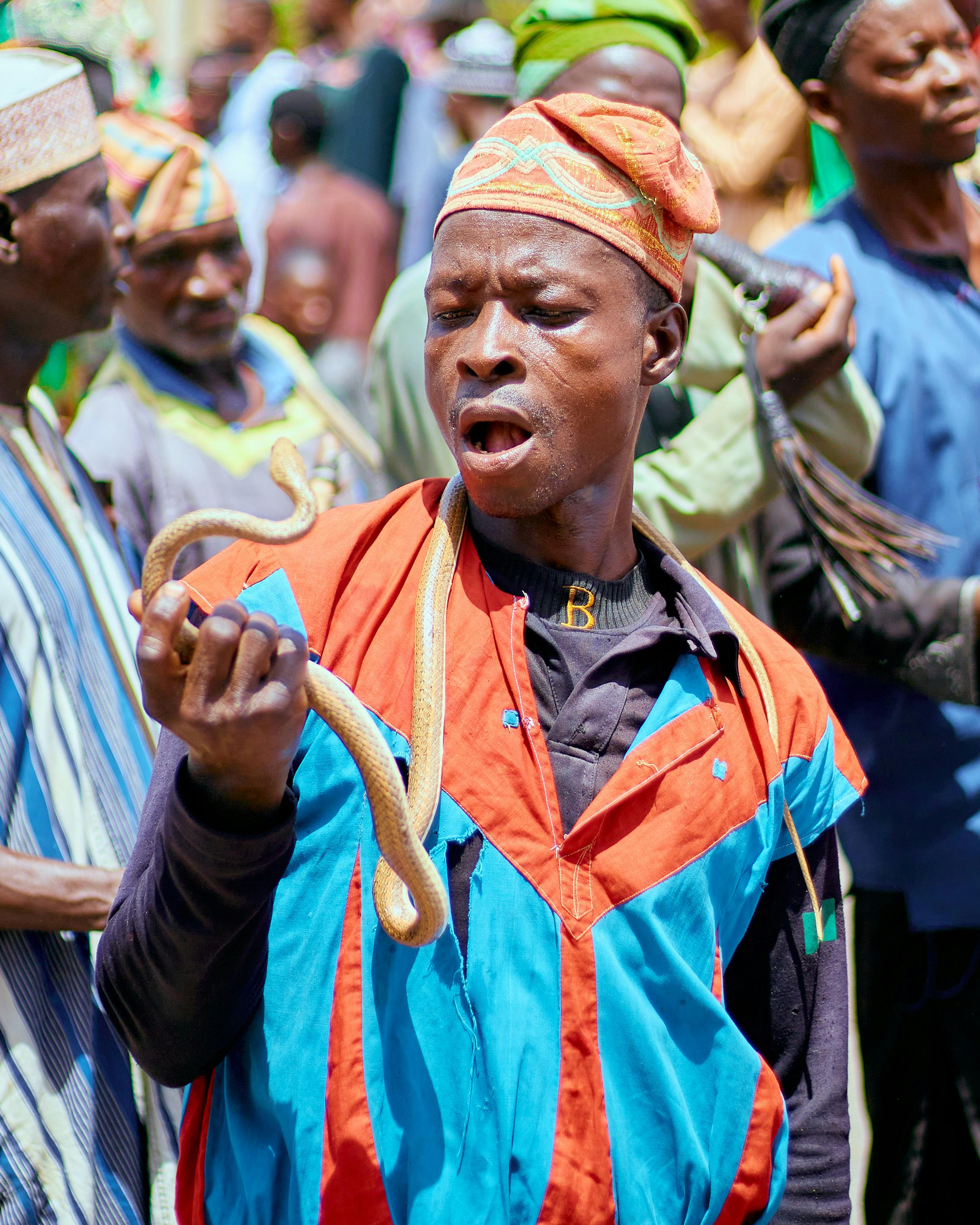 African Man Holding Snake in Traditional Dress · Free Stock Photo