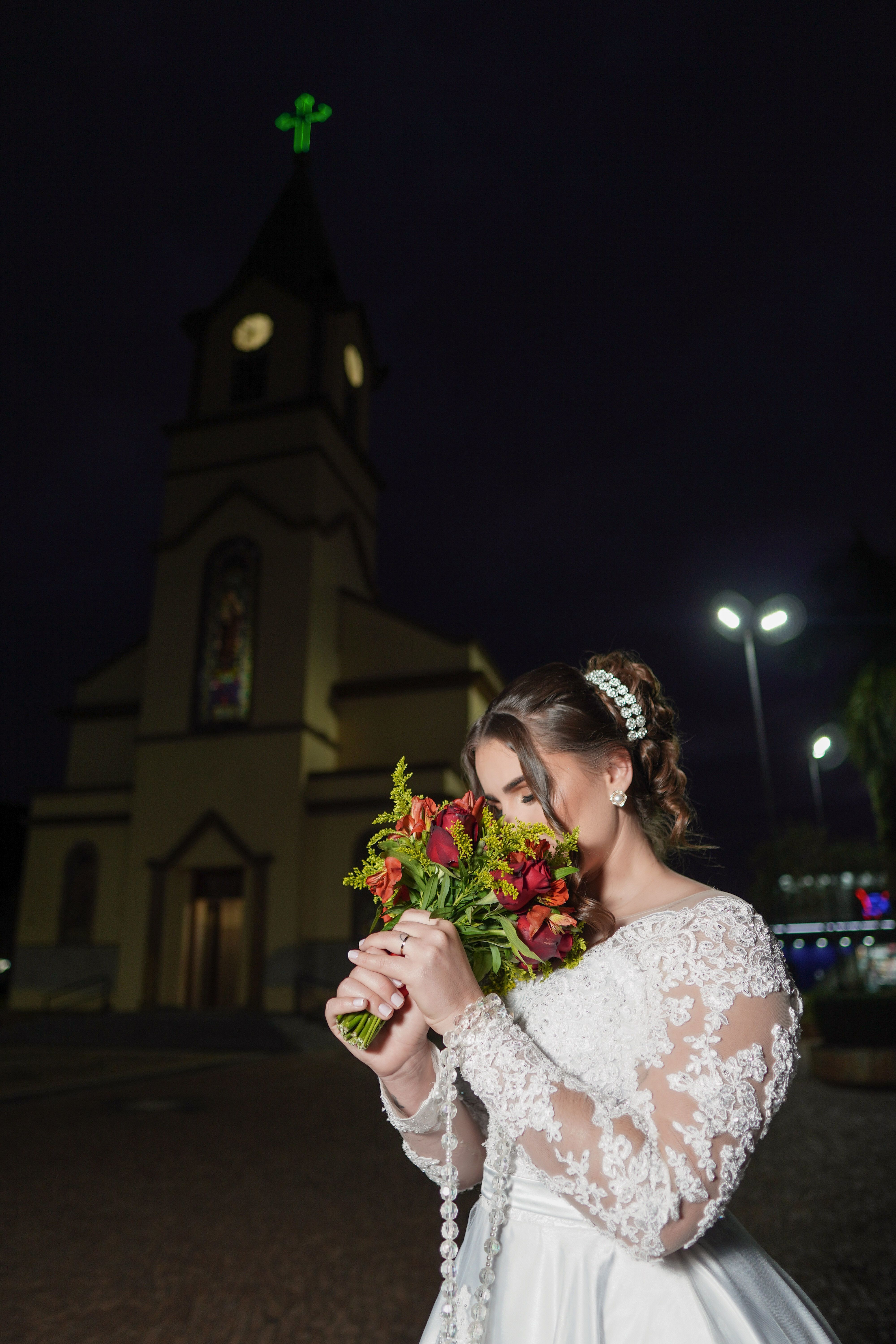 Bride at Night in Front of Illuminated Church · Free Stock Photo