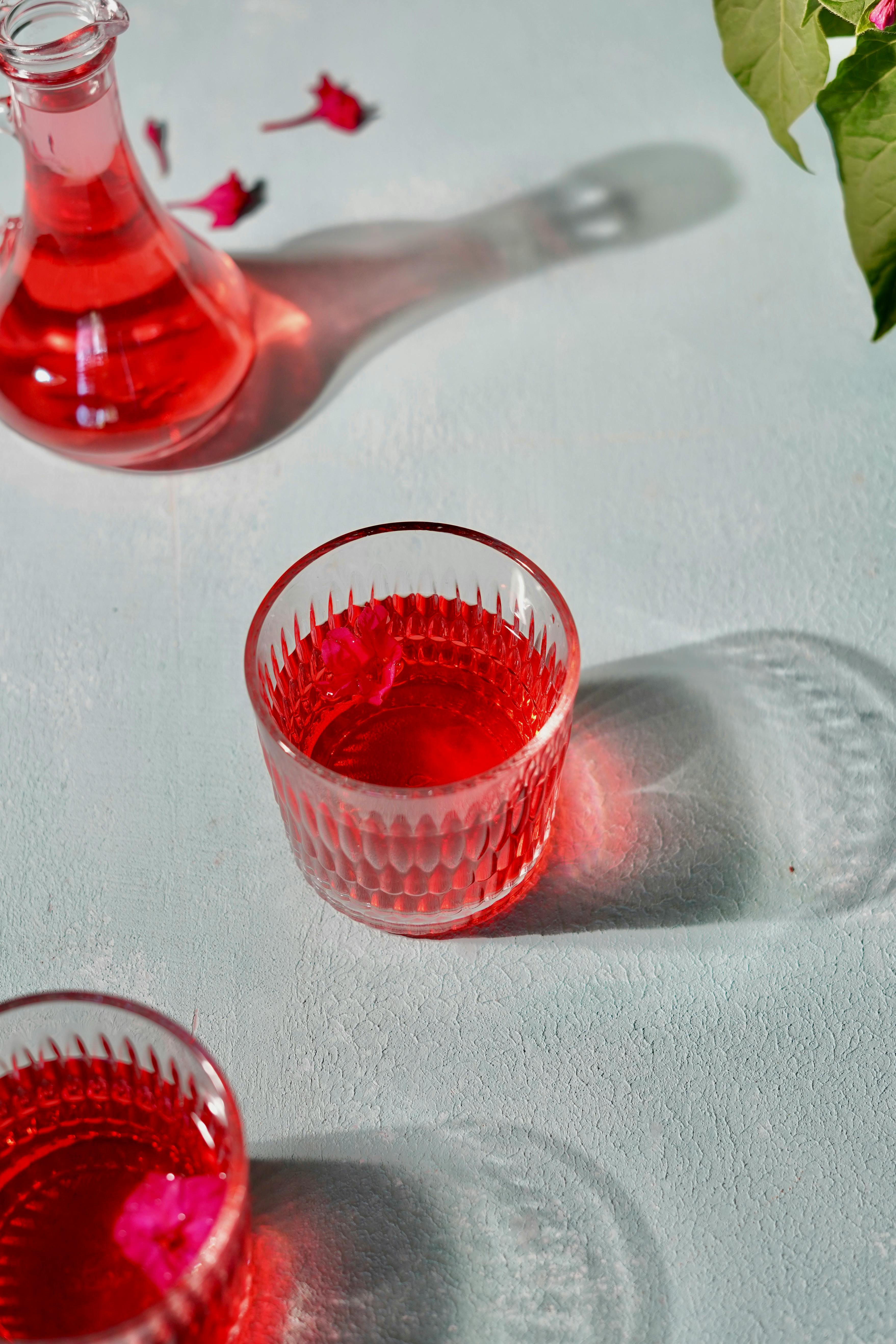Vibrant Red Drinks on White Surface with Shadows · Free Stock Photo