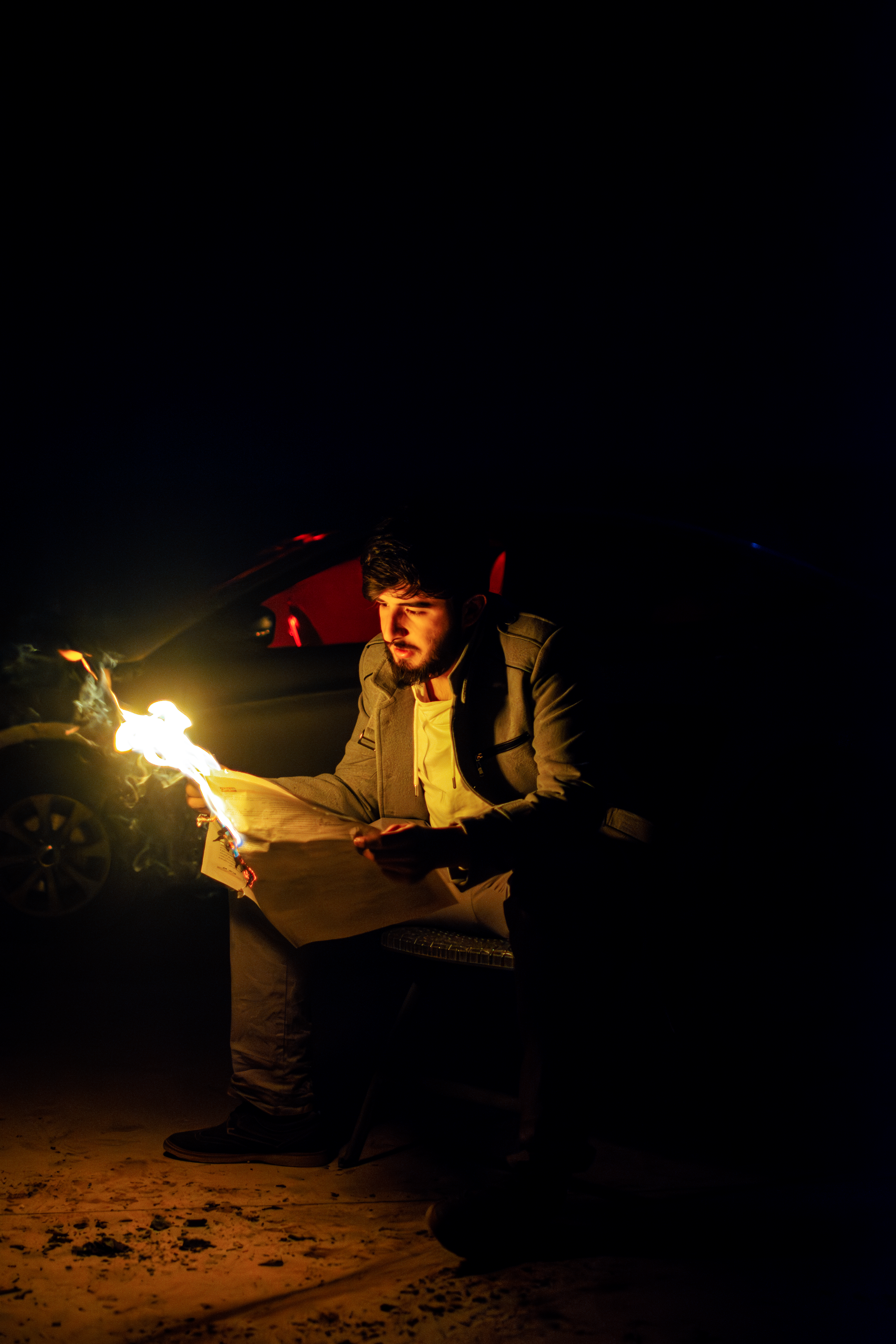 Man Sitting at Night with Burning Paper in Hand · Free Stock Photo