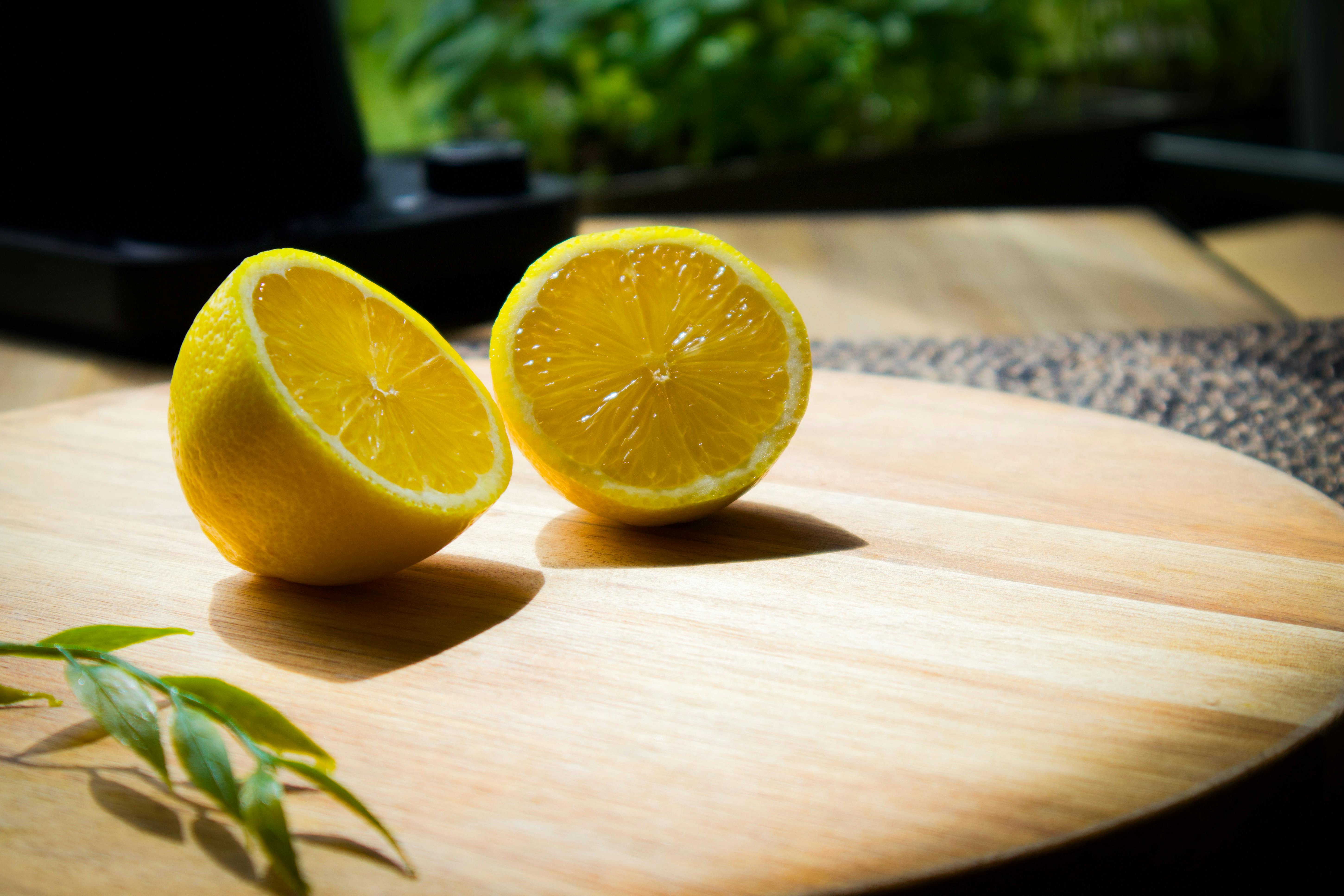 Close-up of Fresh Lemon Halves on Wooden Board · Free Stock Photo