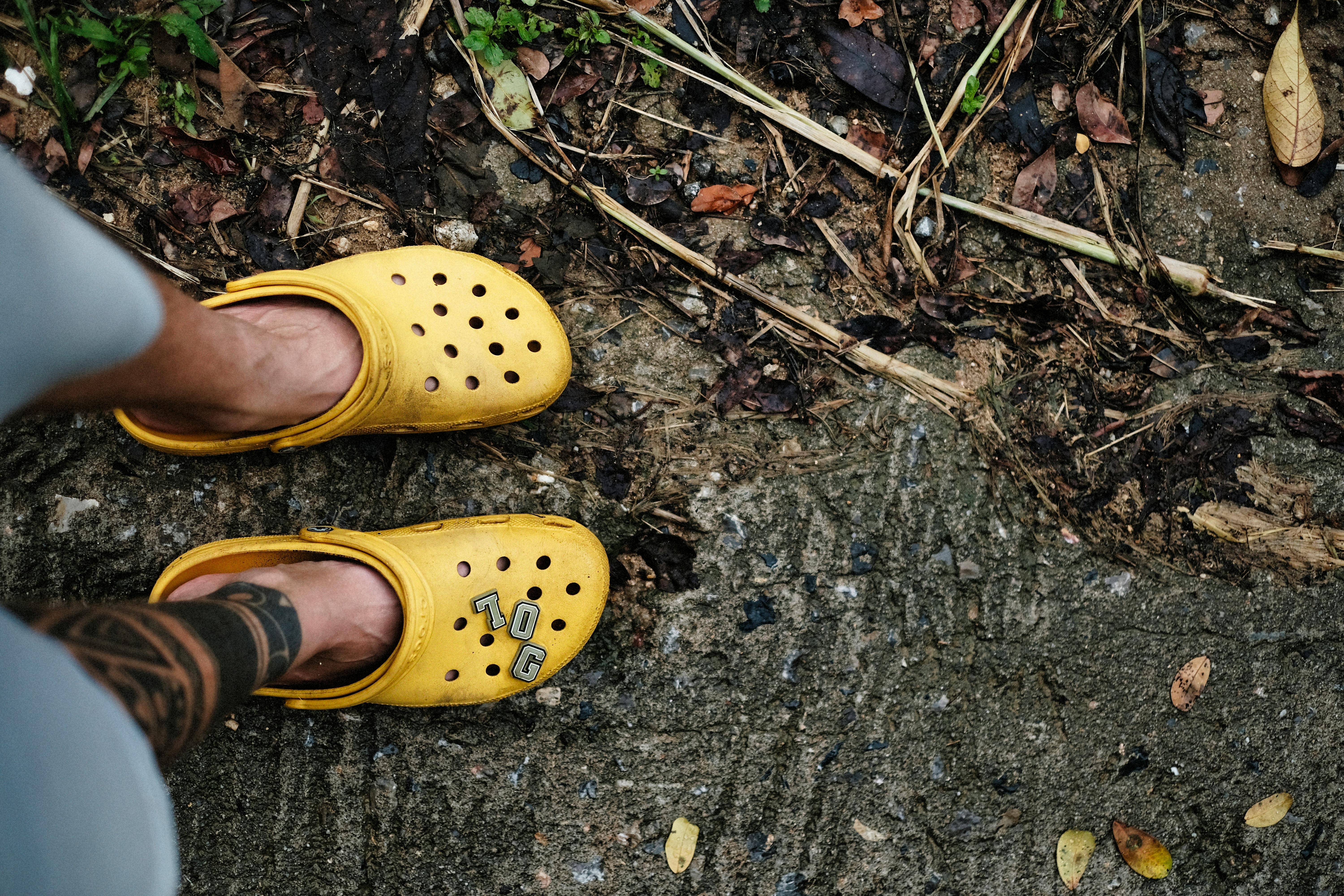 Person Wearing Yellow Crocs on Nature Walk · Free Stock Photo