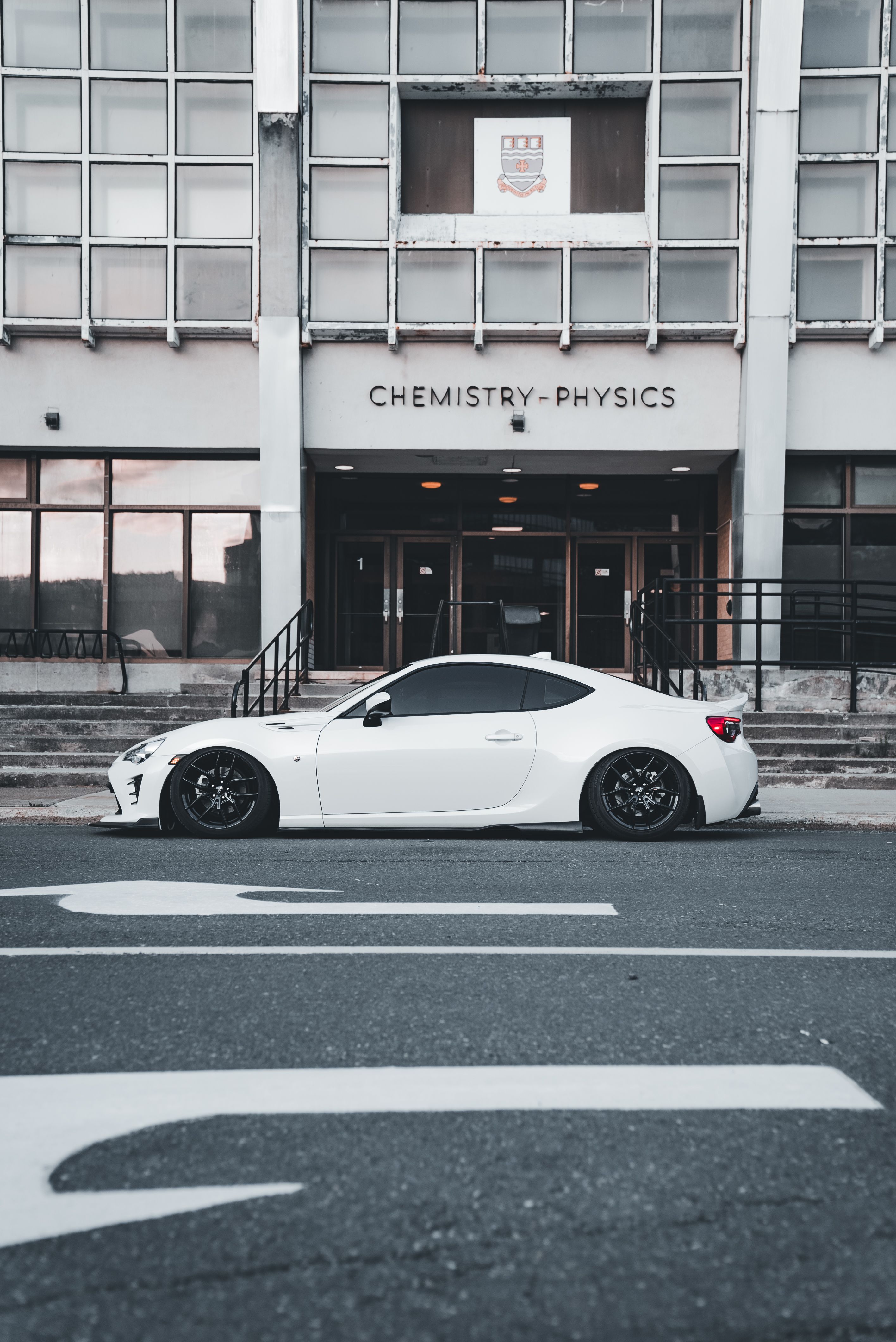 White Sports Car in Front of University Building · Free Stock Photo