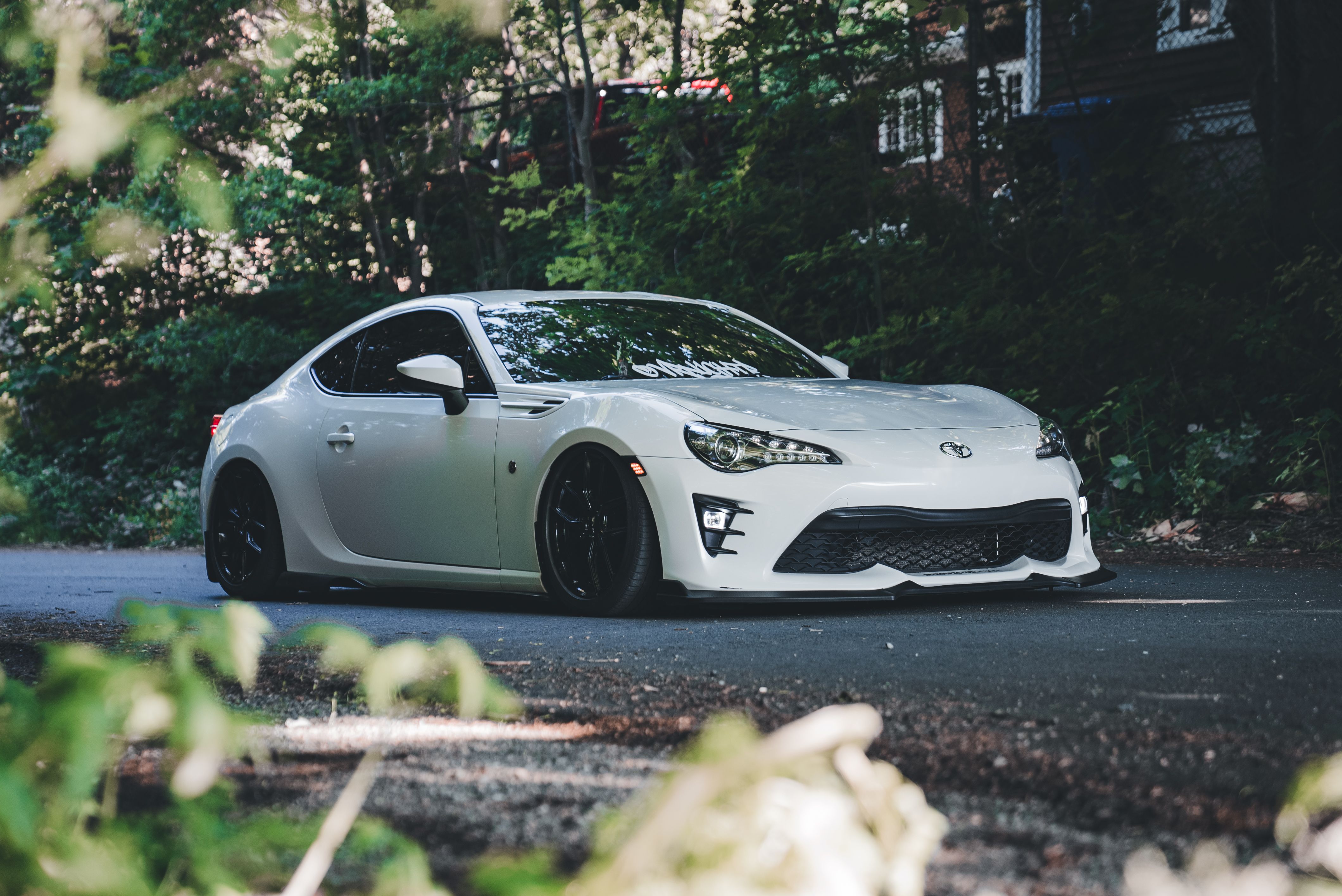 Sleek White Sports Car on Tree-Lined Road · Free Stock Photo