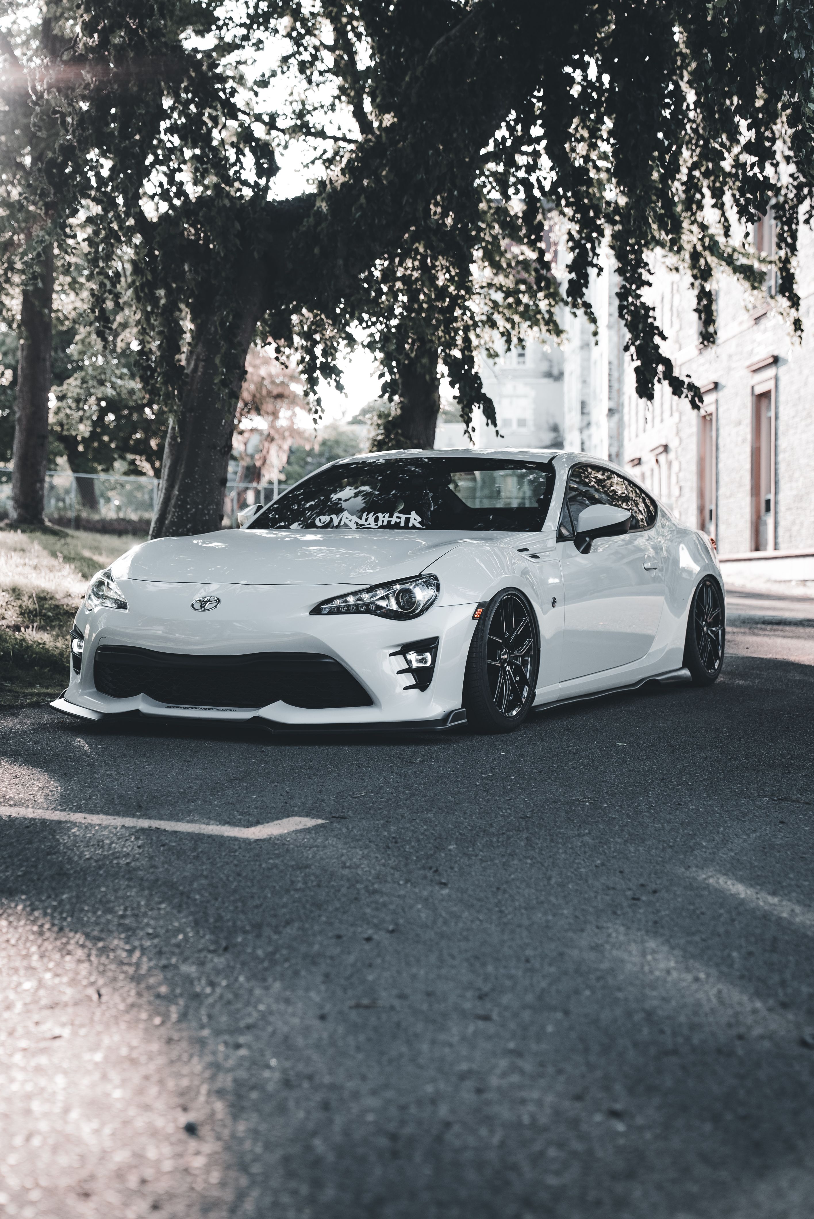 Low Profile White Sports Car on Urban Street · Free Stock Photo