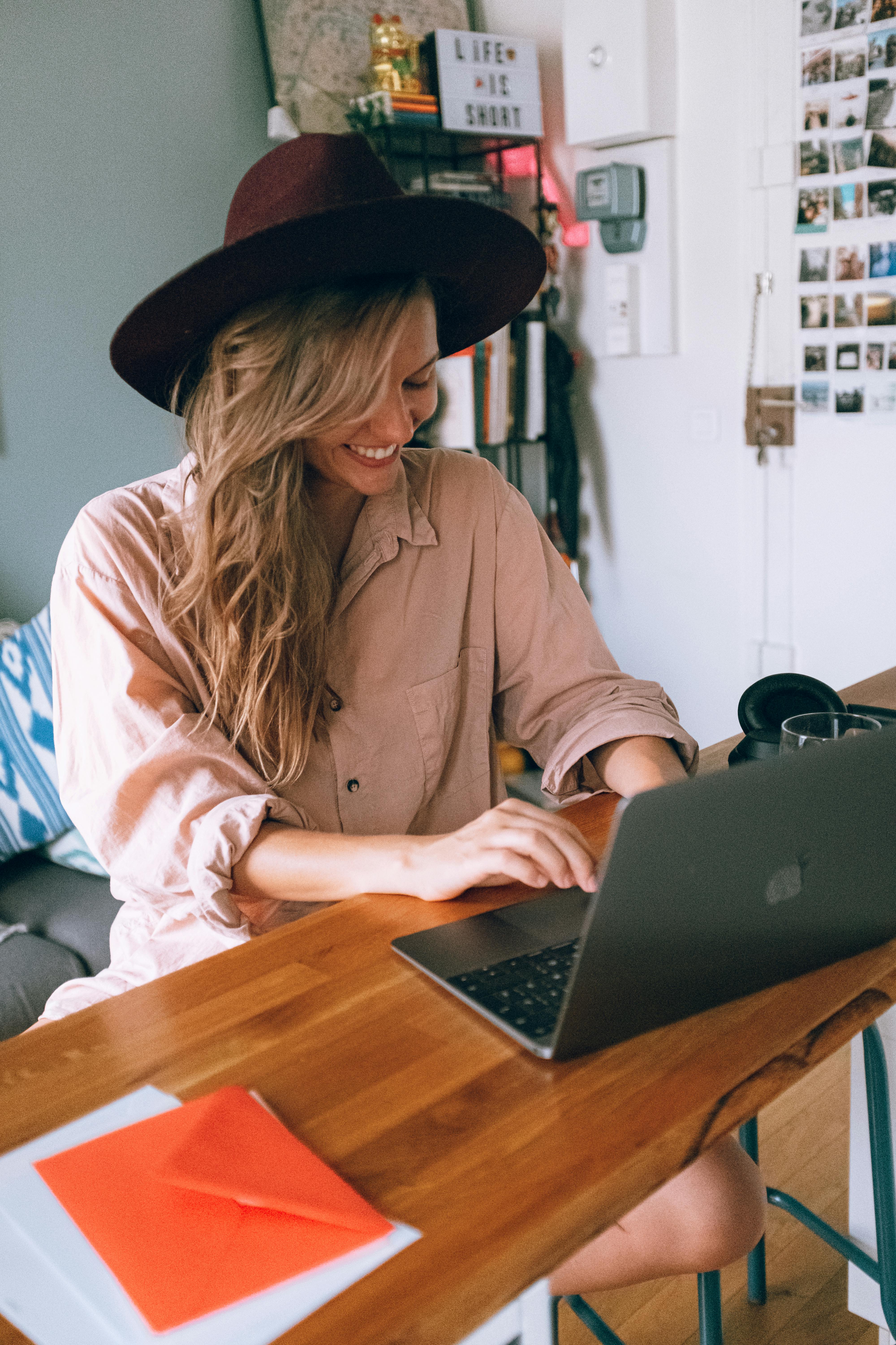 Woman in White Long Sleeve Shirt and Blue Denim Jeans While Using ...